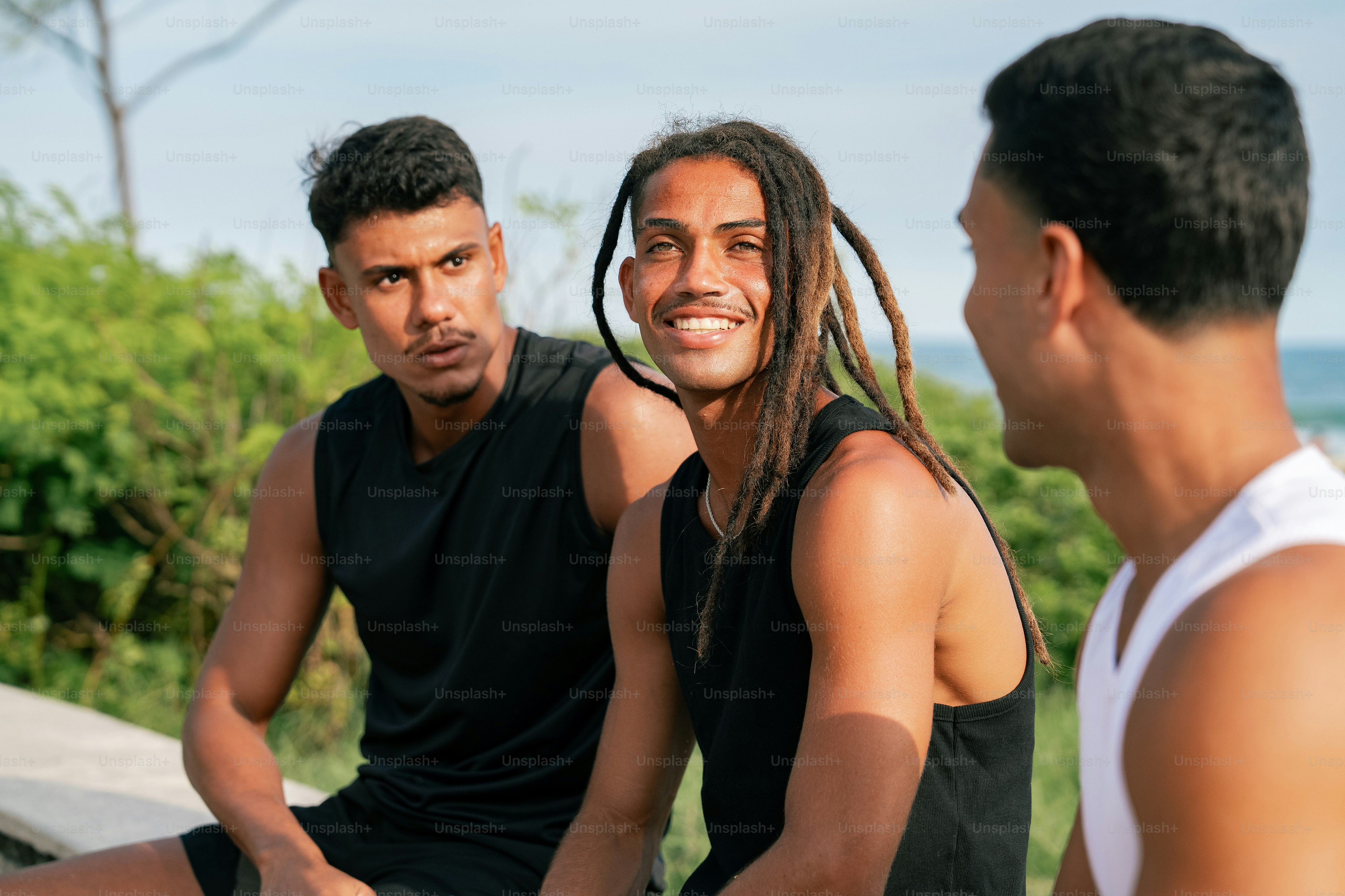 A group of three men standing next to each other holding a soccer ball ...