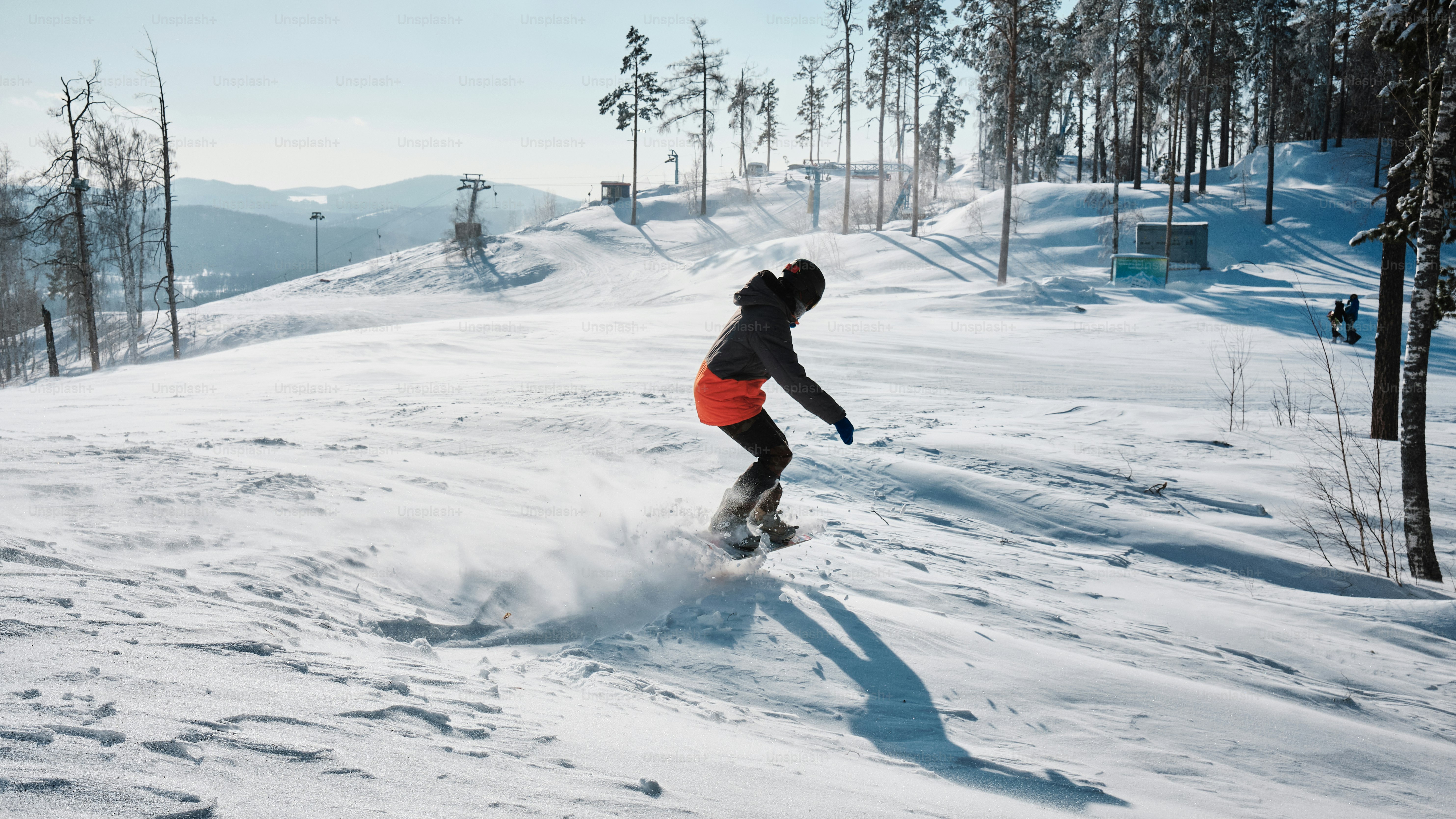 A person riding a snowboard down a snow covered slope photo ...