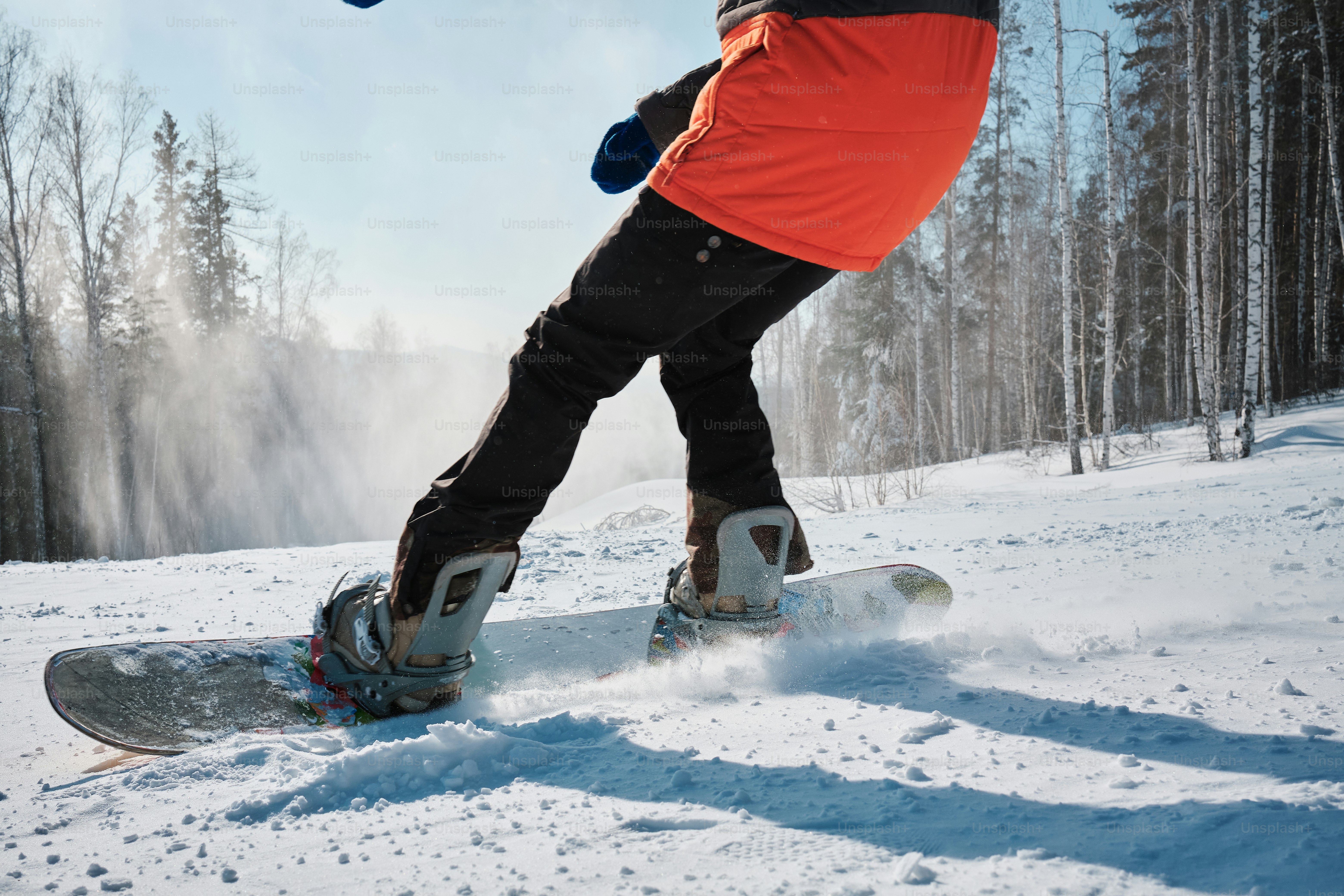 A person riding a snowboard on a snowy surface photo – Snowboarding ...