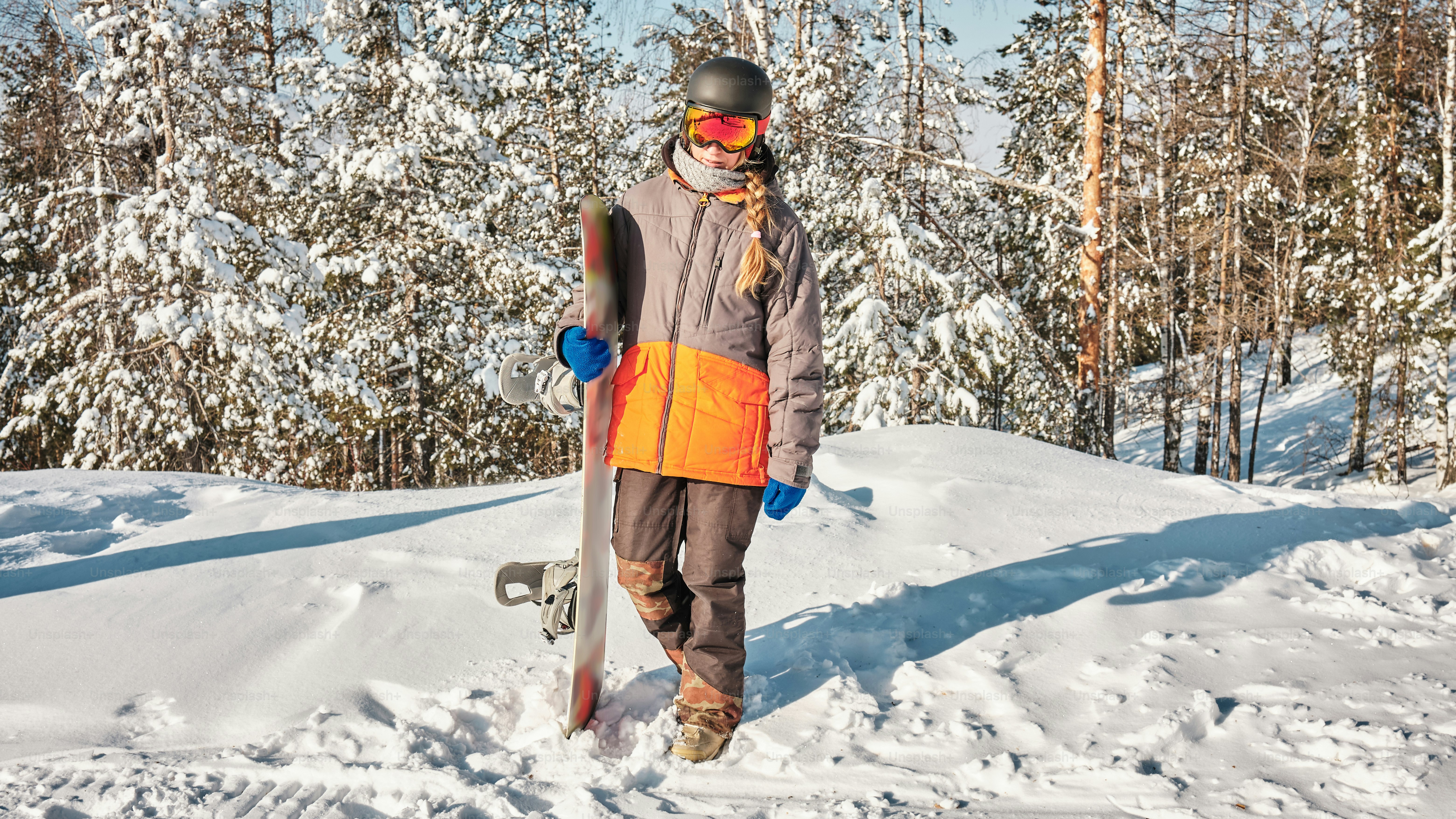 A snowboarder is standing in the snow with his board photo – Snow Image ...