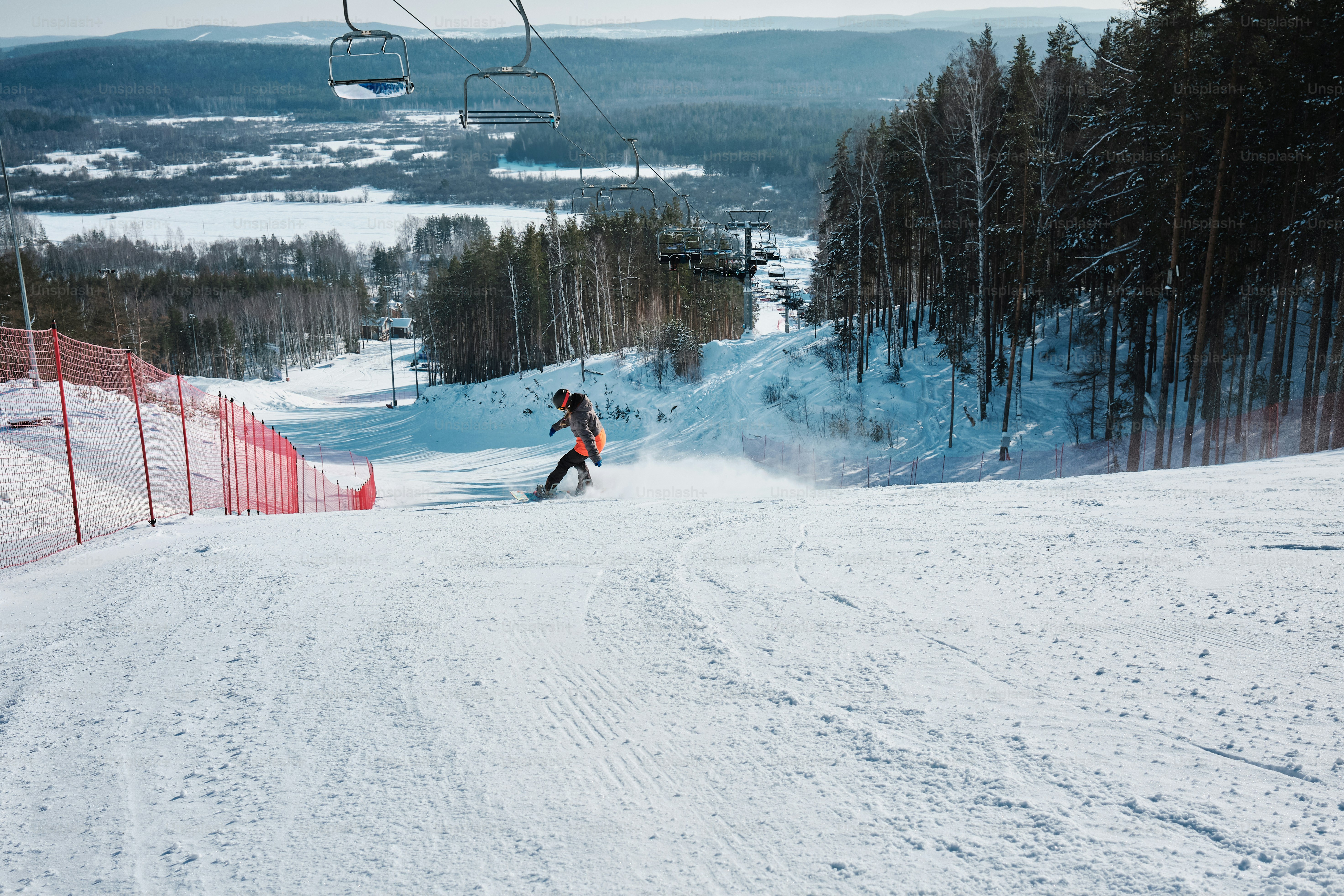 A person riding a snowboard down a snow covered slope photo ...