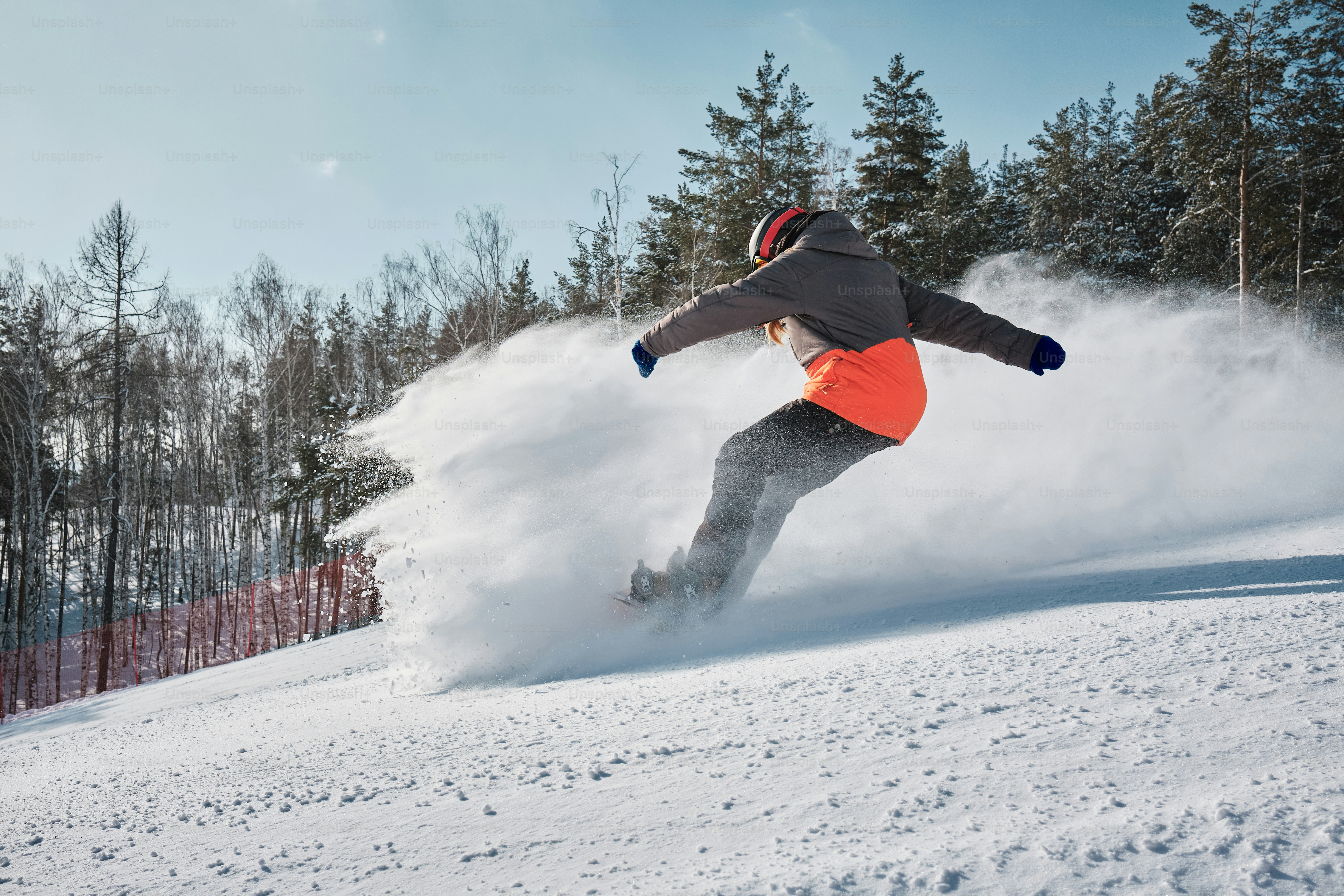A person riding a snowboard down a snow covered slope photo ...