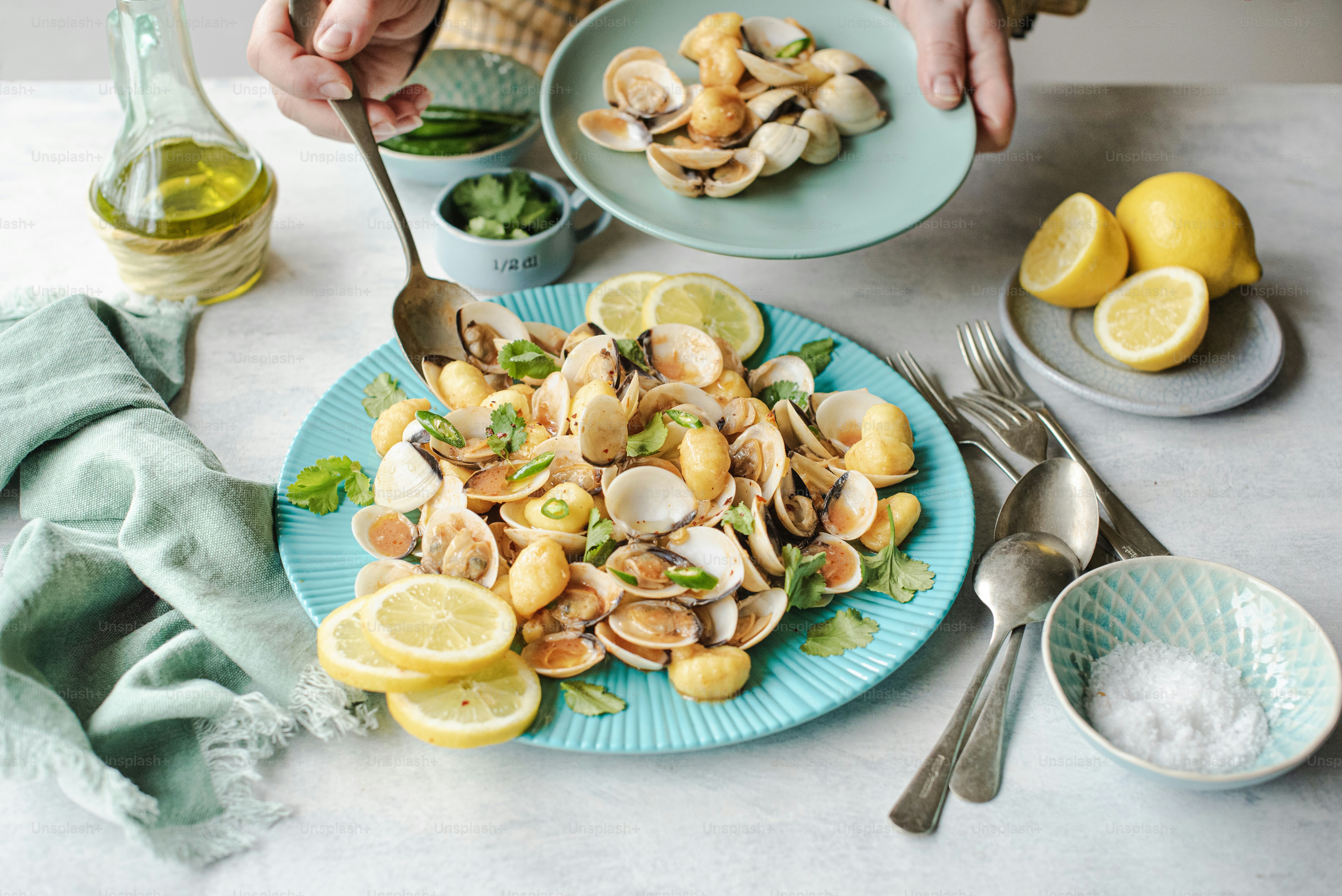 A plate of clams and lemons on a table photo – Clams Image on Unsplash
