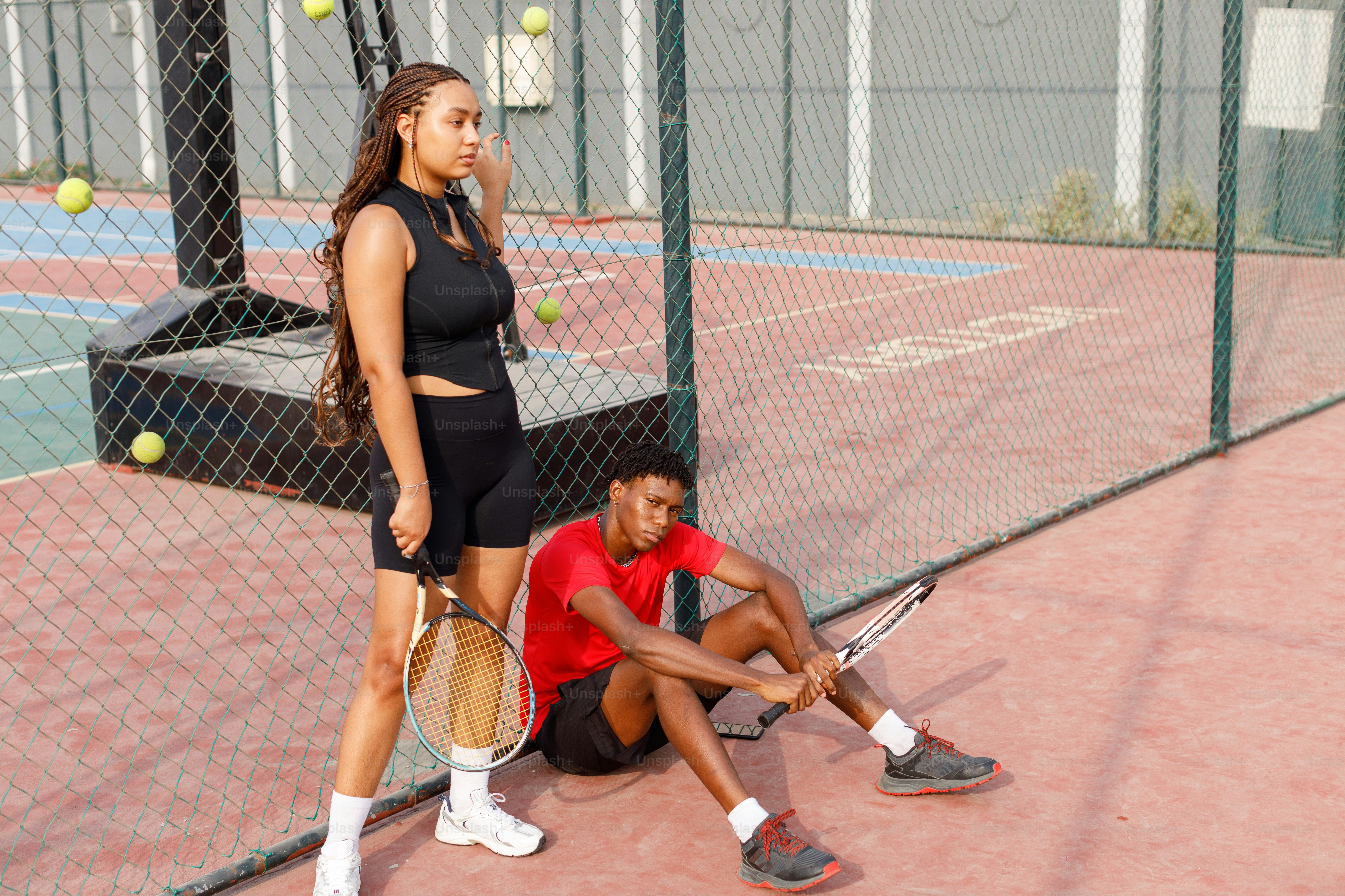 A couple of people that are on a court with tennis rackets photo ...