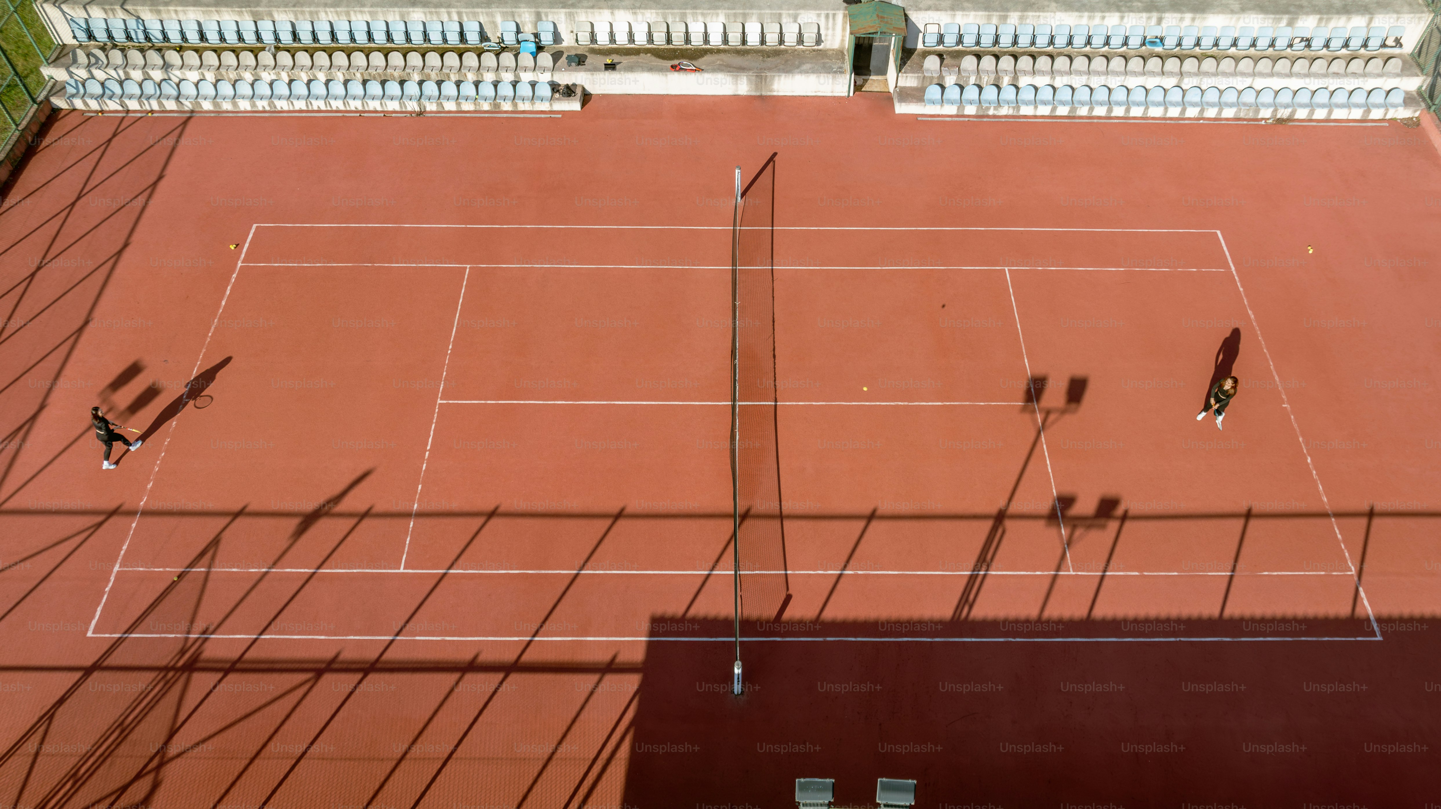 A couple of people standing on a tennis court holding racquets photo ...