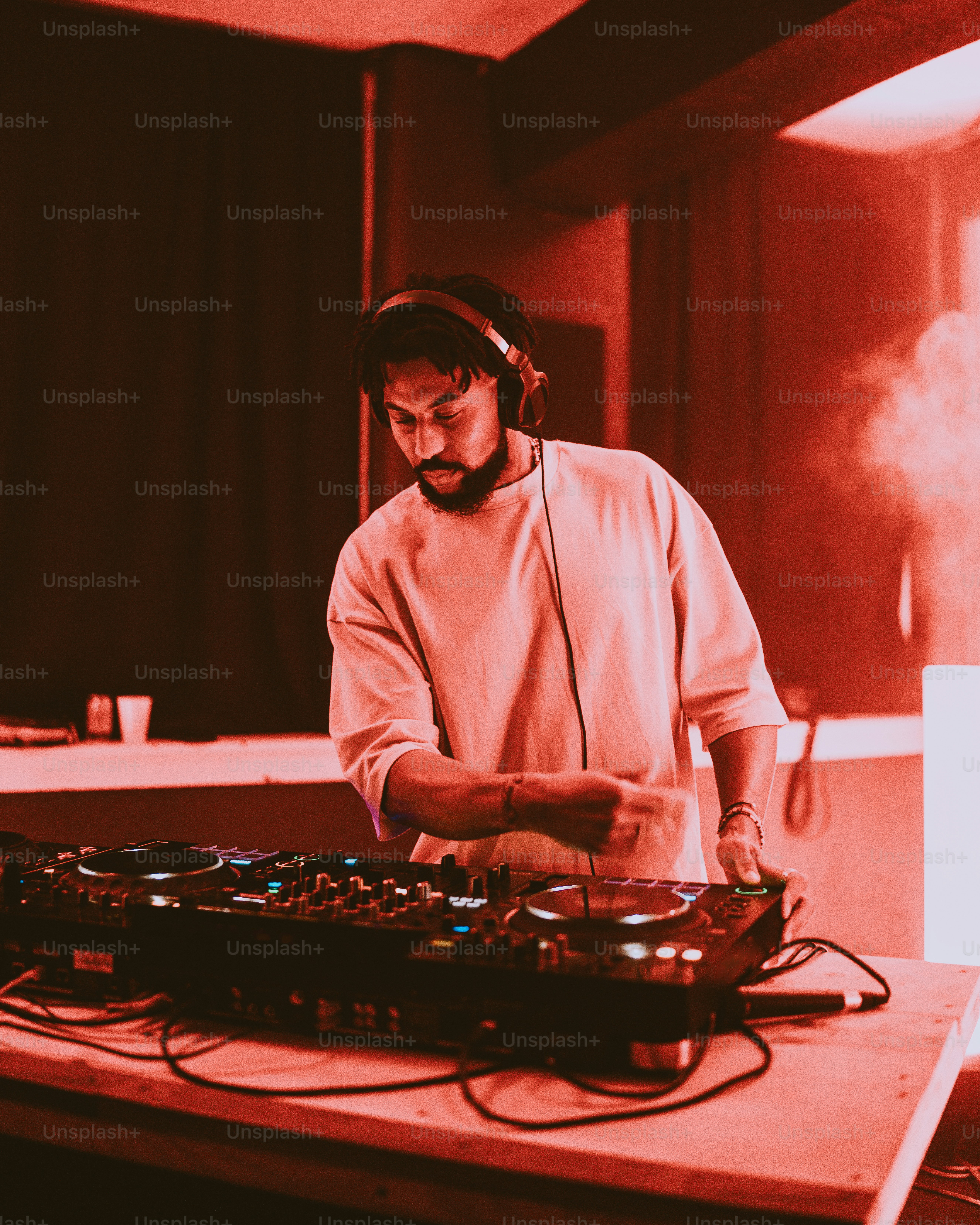 A man that is standing in front of a dj's mixer photo – Dj Image on ...