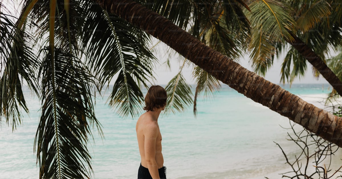 Foto Un Hombre Parado En Una Playa Junto A Una Palmera Maldivas