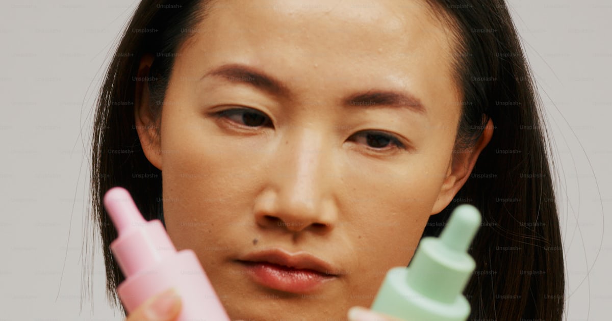 A Woman Holding A Small Bottle Of Lotion And A Small Bottle Of Lotion Photo Woman Image On