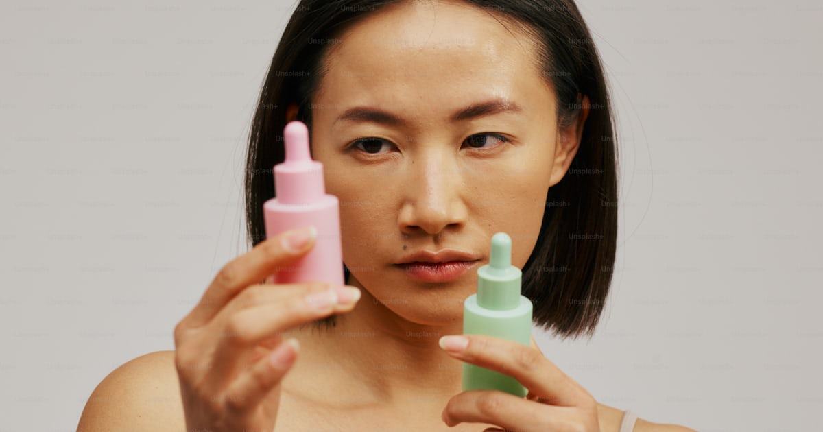 A Woman Holding A Small Bottle And A Small Bottle Photo Skincare Image On Unsplash