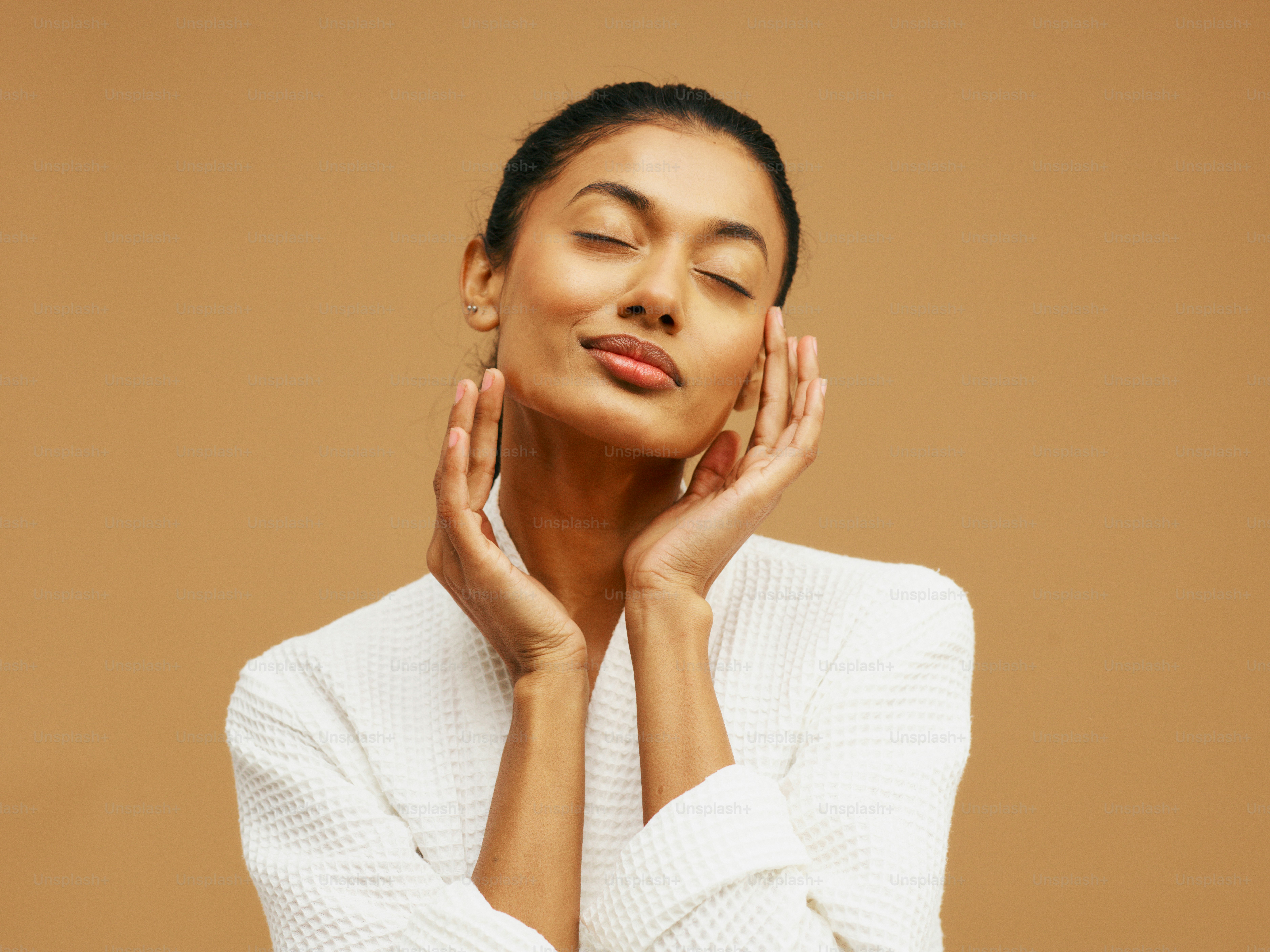 A woman smiling and touching her face with her hand photo – Skin Image ...