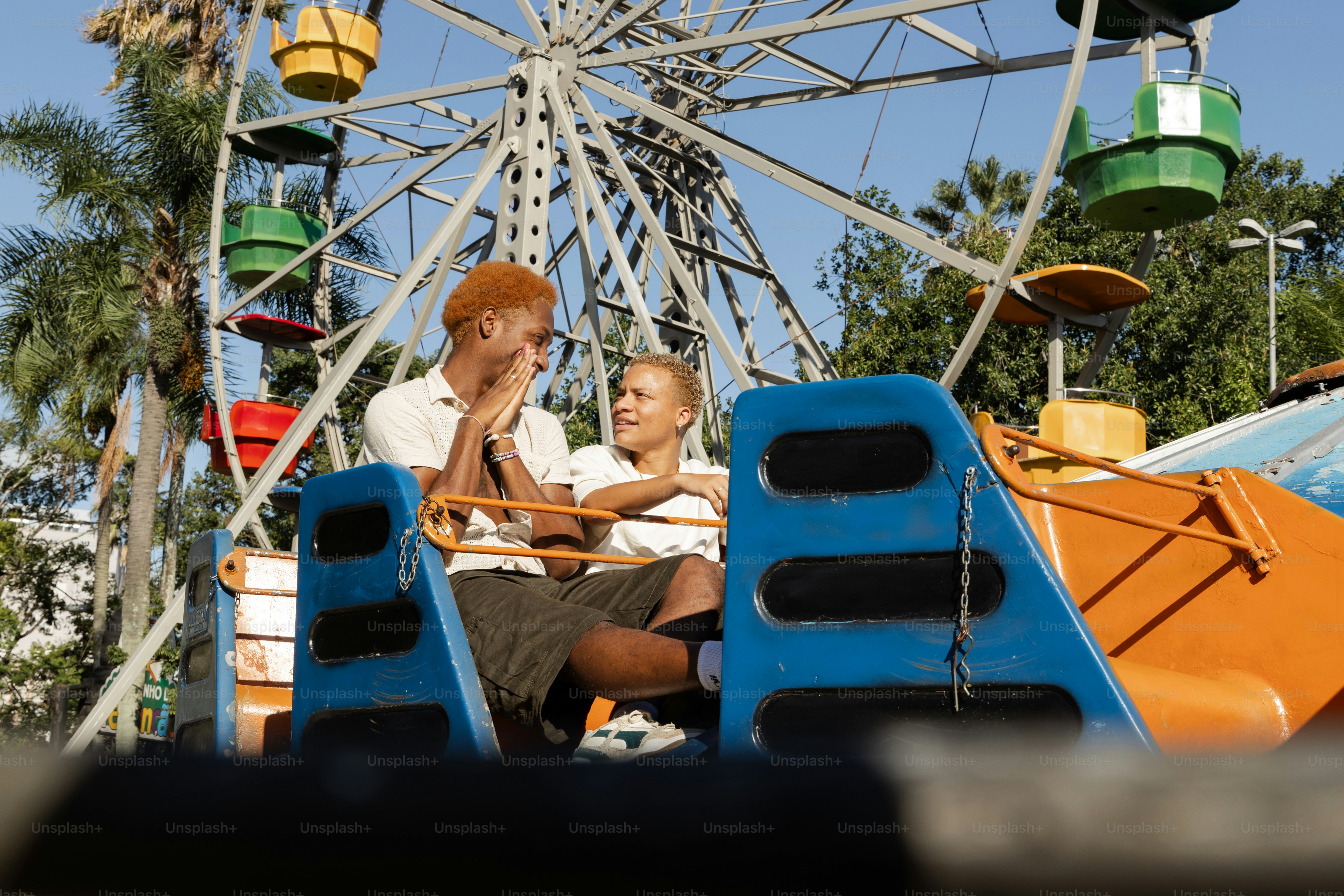 A man and a woman sitting on a carnival ride photo – Amusement park ...
