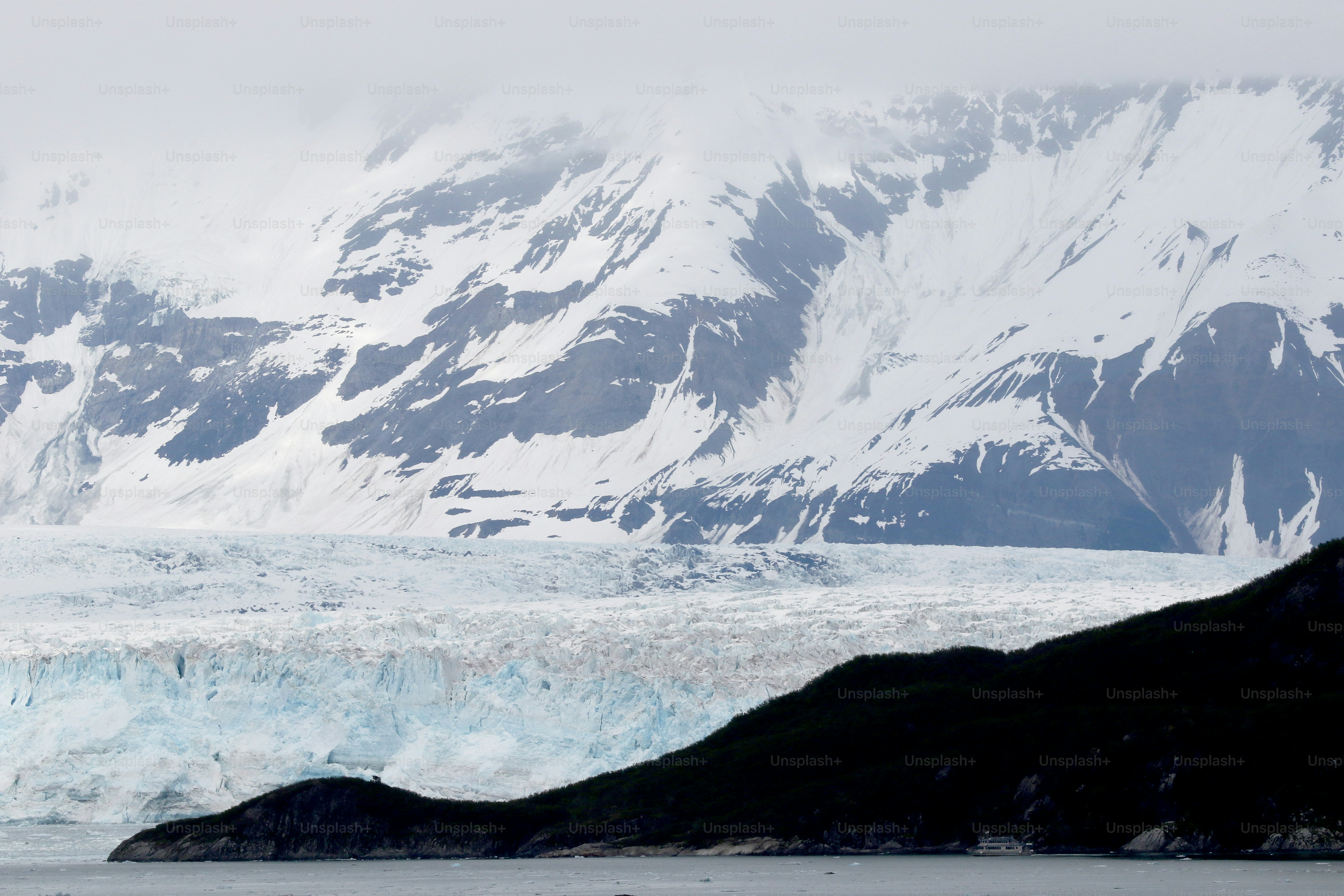 A large glacier with mountains in the background photo – Glacier Image ...