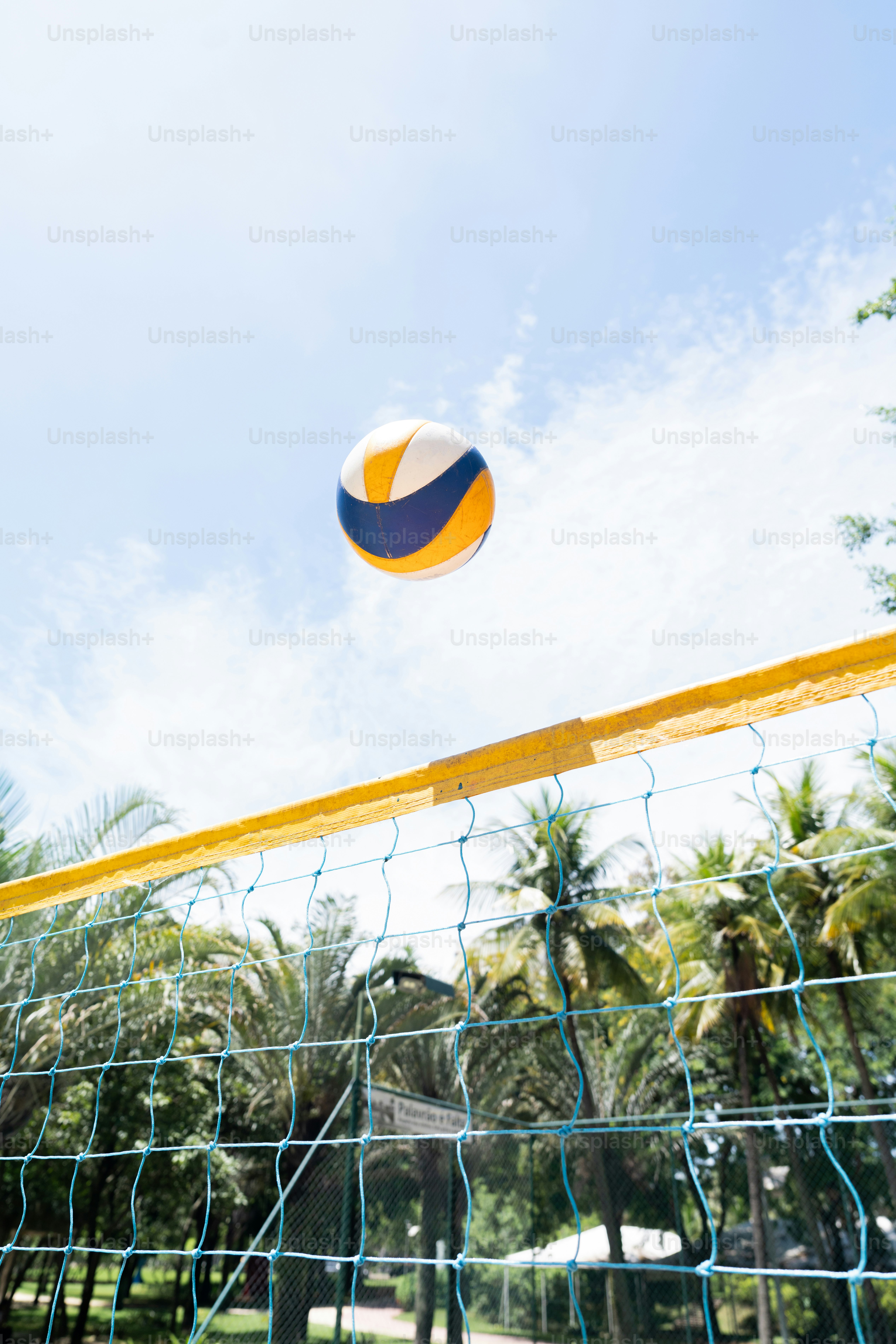A volleyball is hitting the ball over the net photo – Sport Image on ...