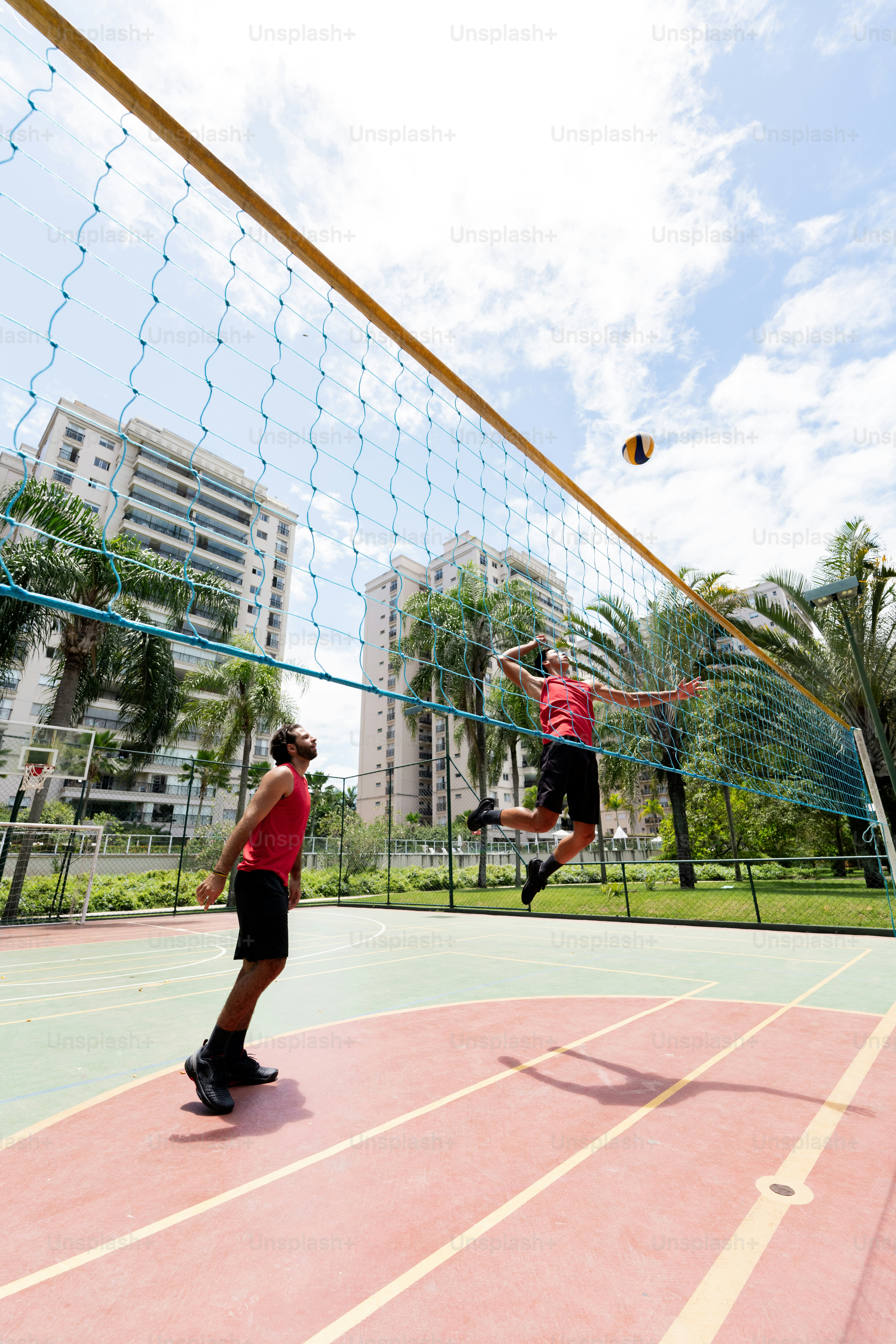 Um casal de homens jogando uma partida de vôlei foto – Imagem sobre ...