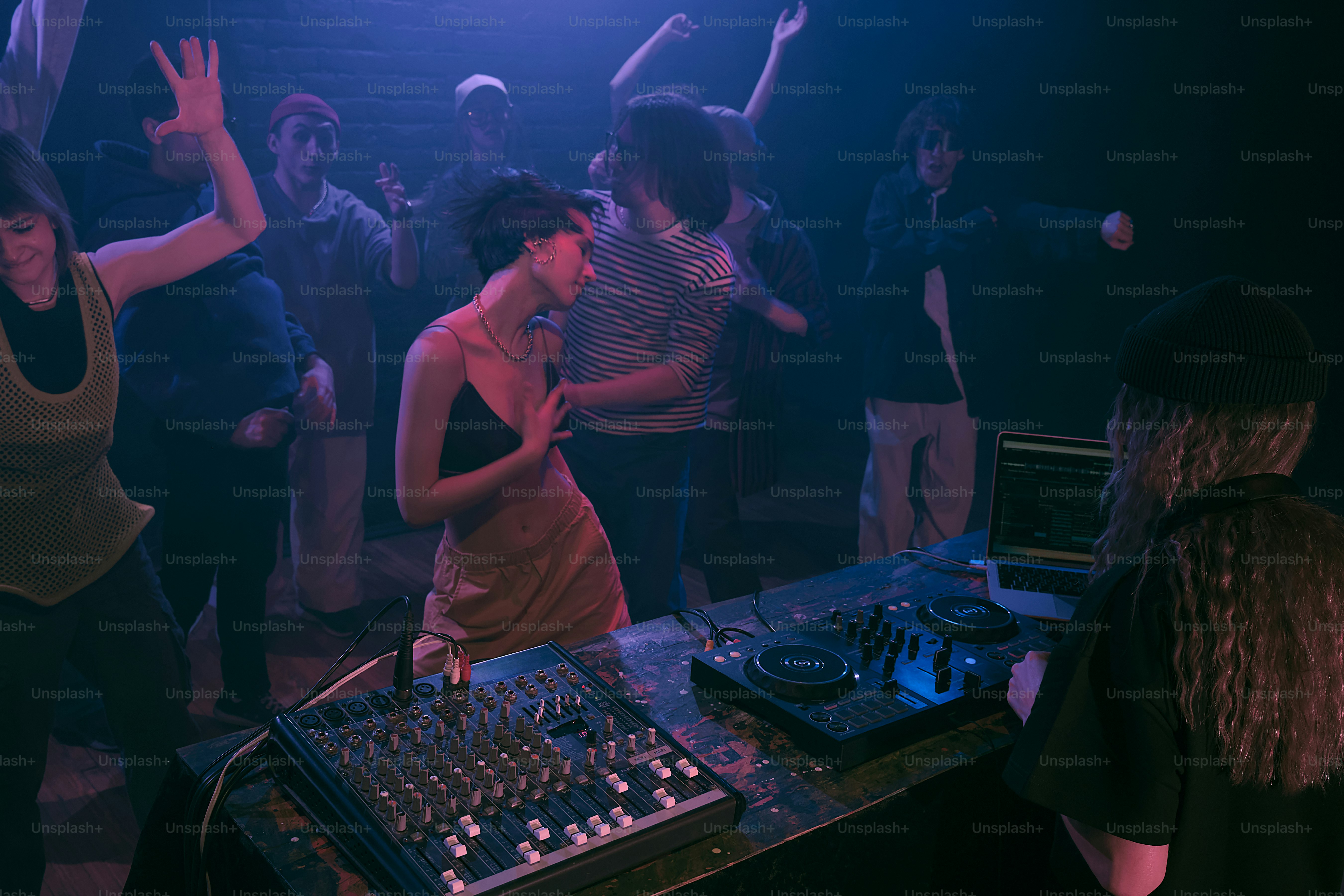 A group of people standing around a dj booth photo – Rave Image on Unsplash