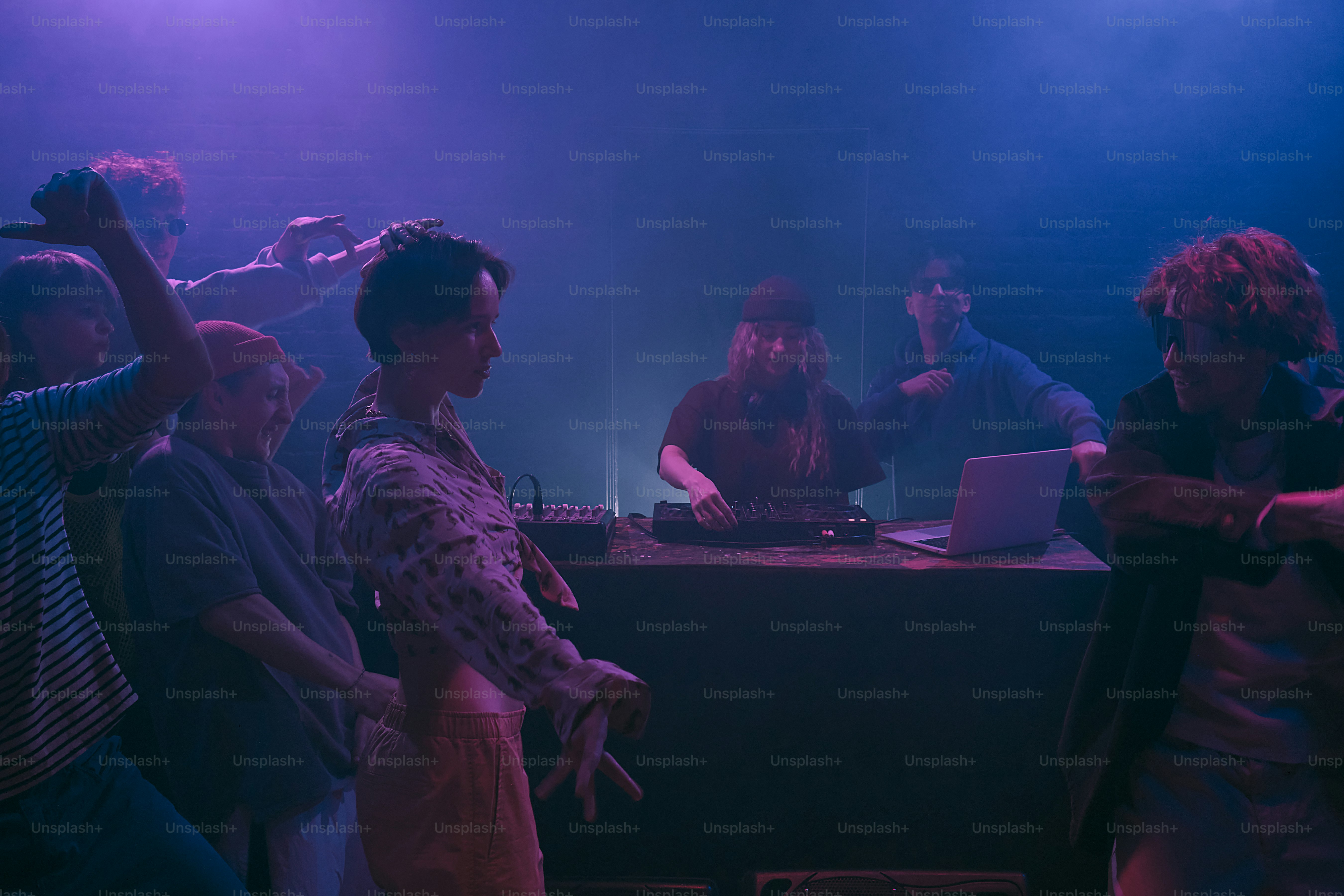A group of people standing around a dj booth photo – Rave Image on Unsplash