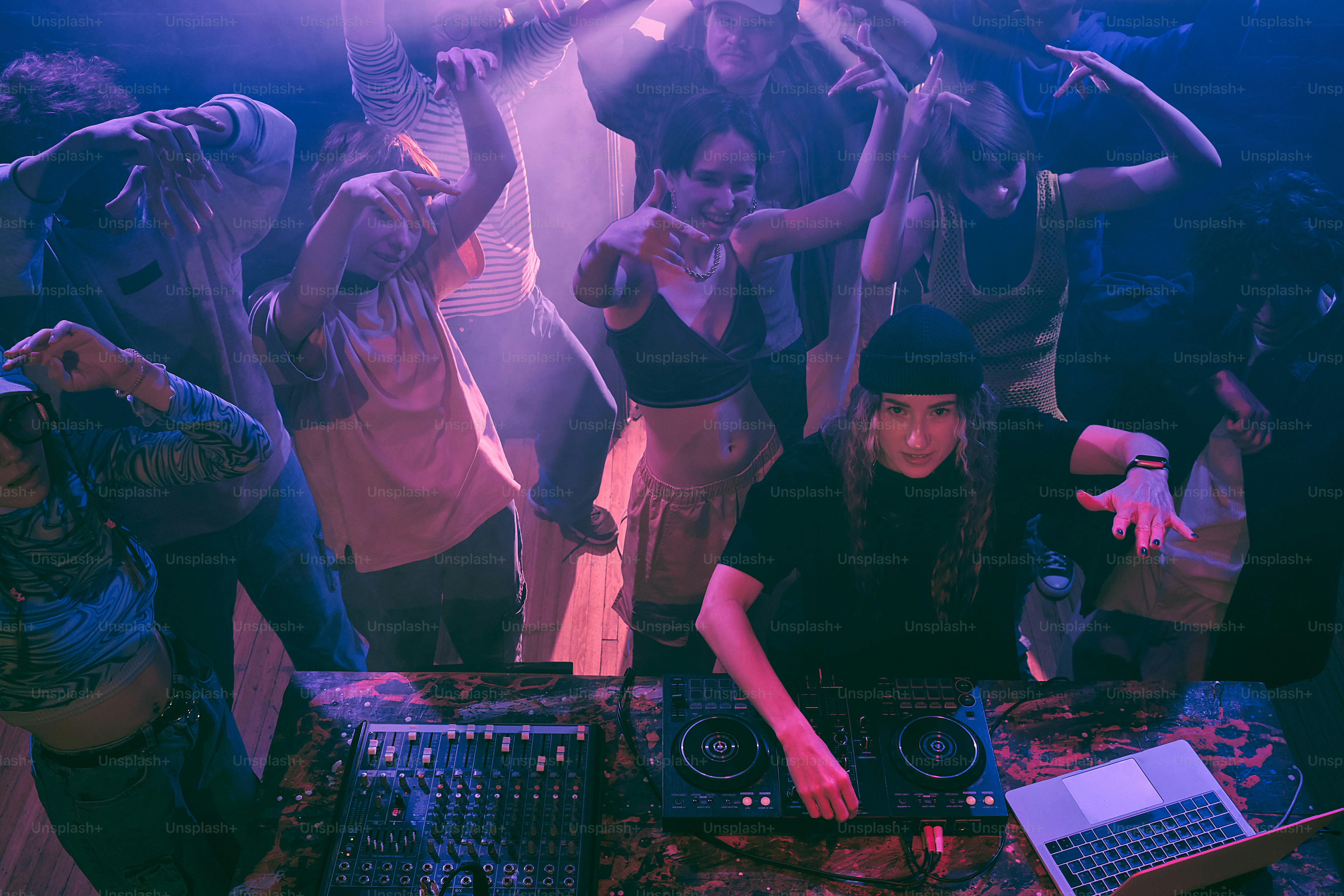 A group of people standing around a dj booth photo – Rave Image on Unsplash