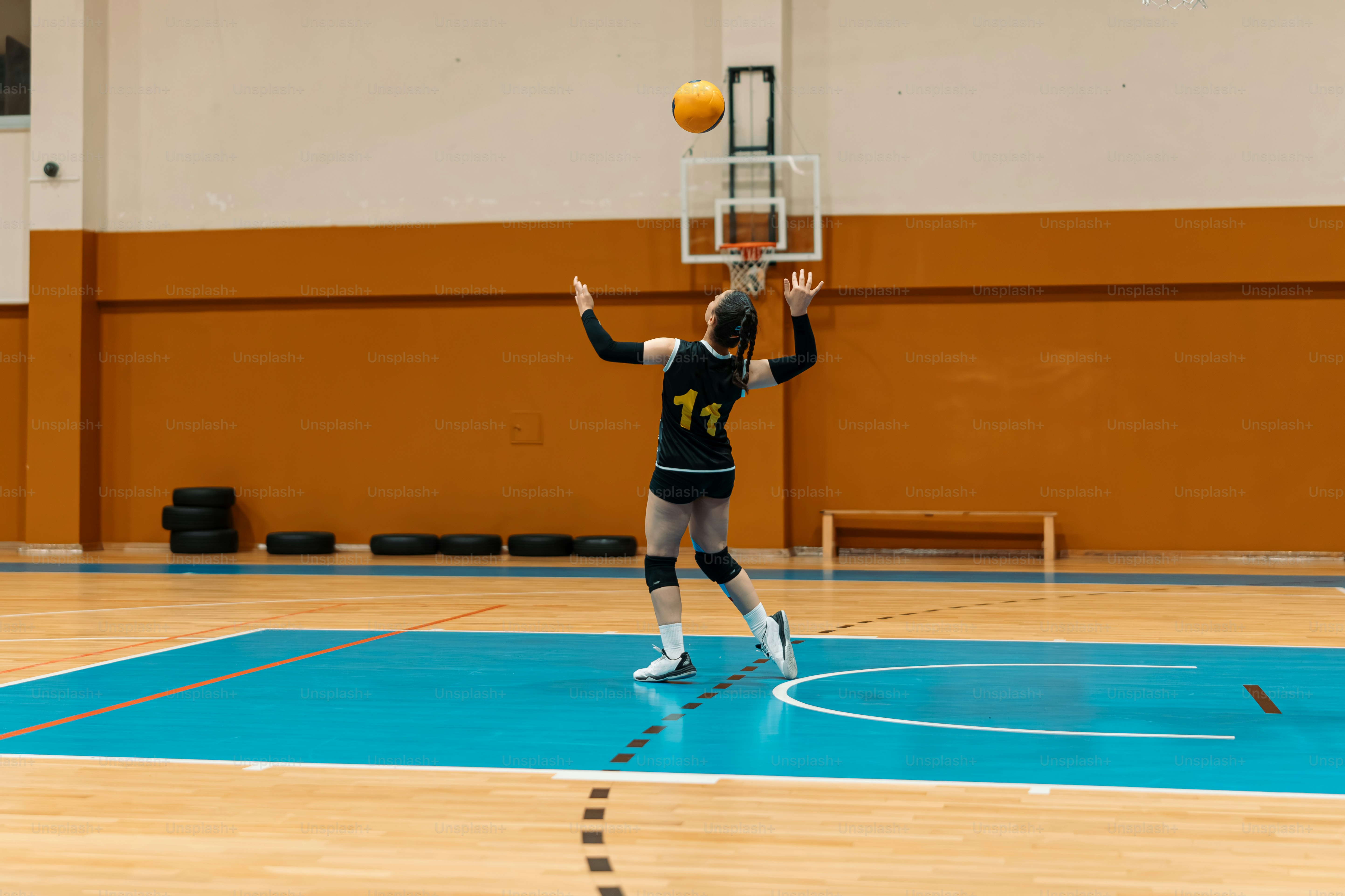 A person jumping up to hit a ball with a racket photo – Team Image on ...