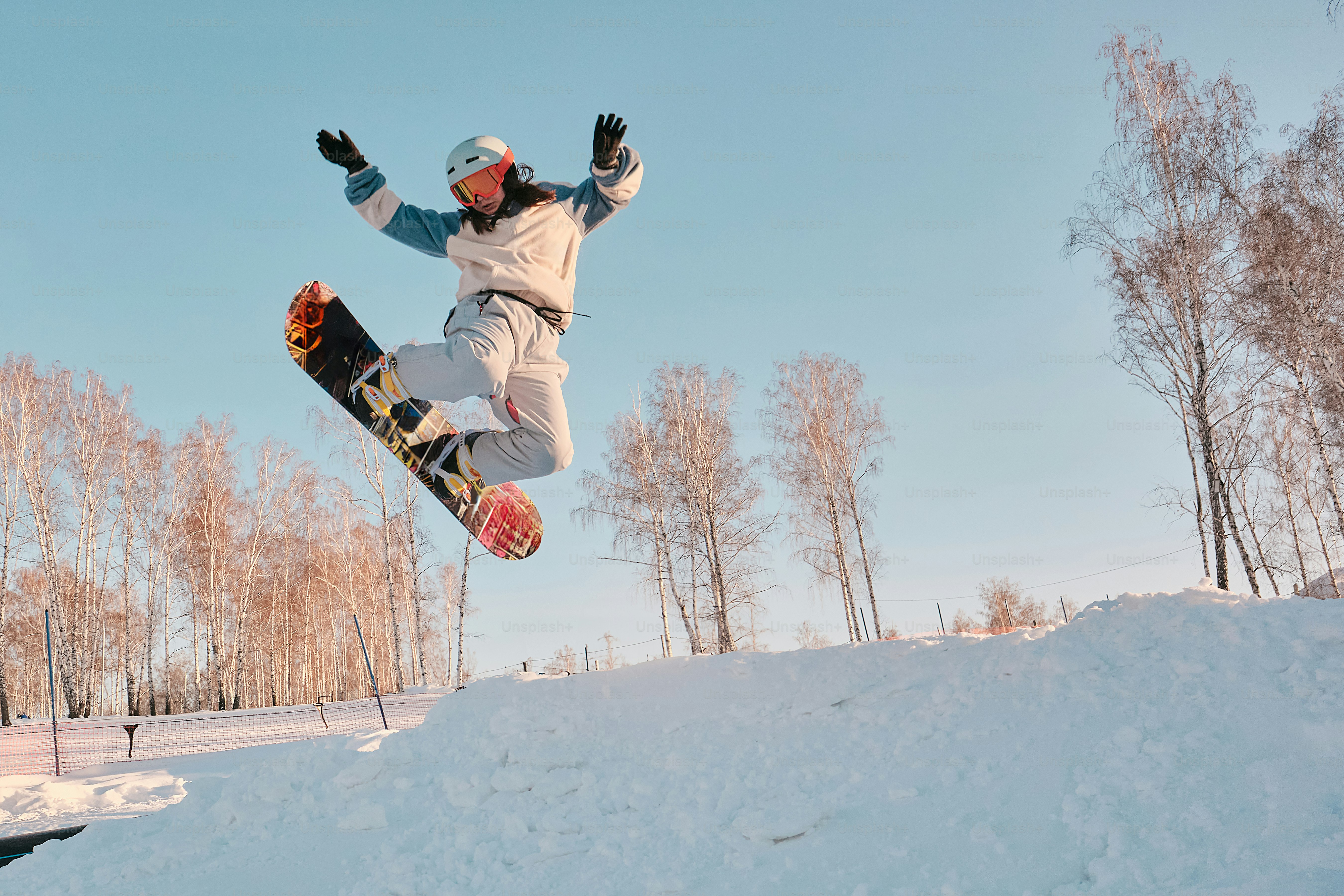 A man flying through the air while riding a snowboard photo ...