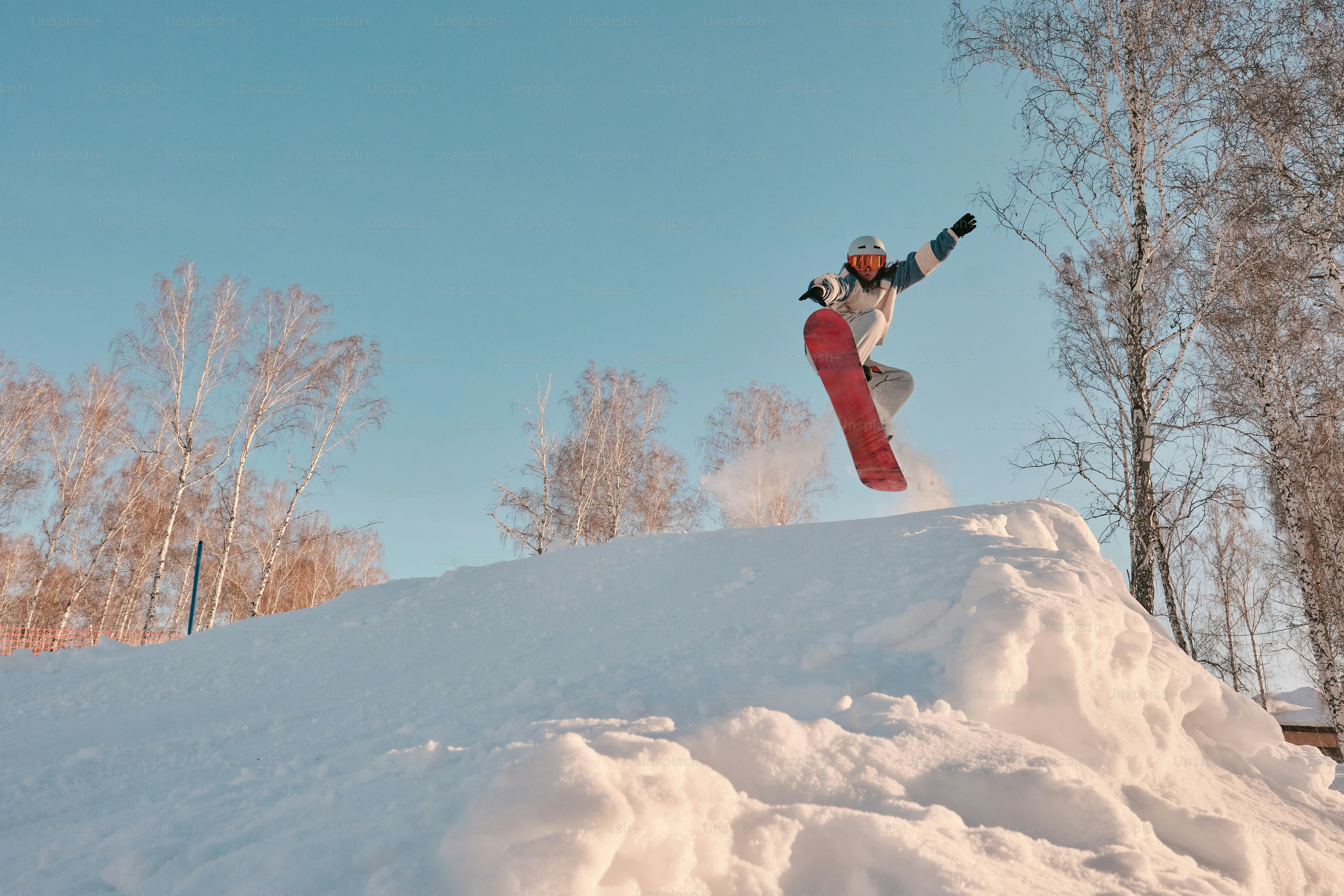 A person on a snowboard jumping in the air photo – Snowboarding Image ...