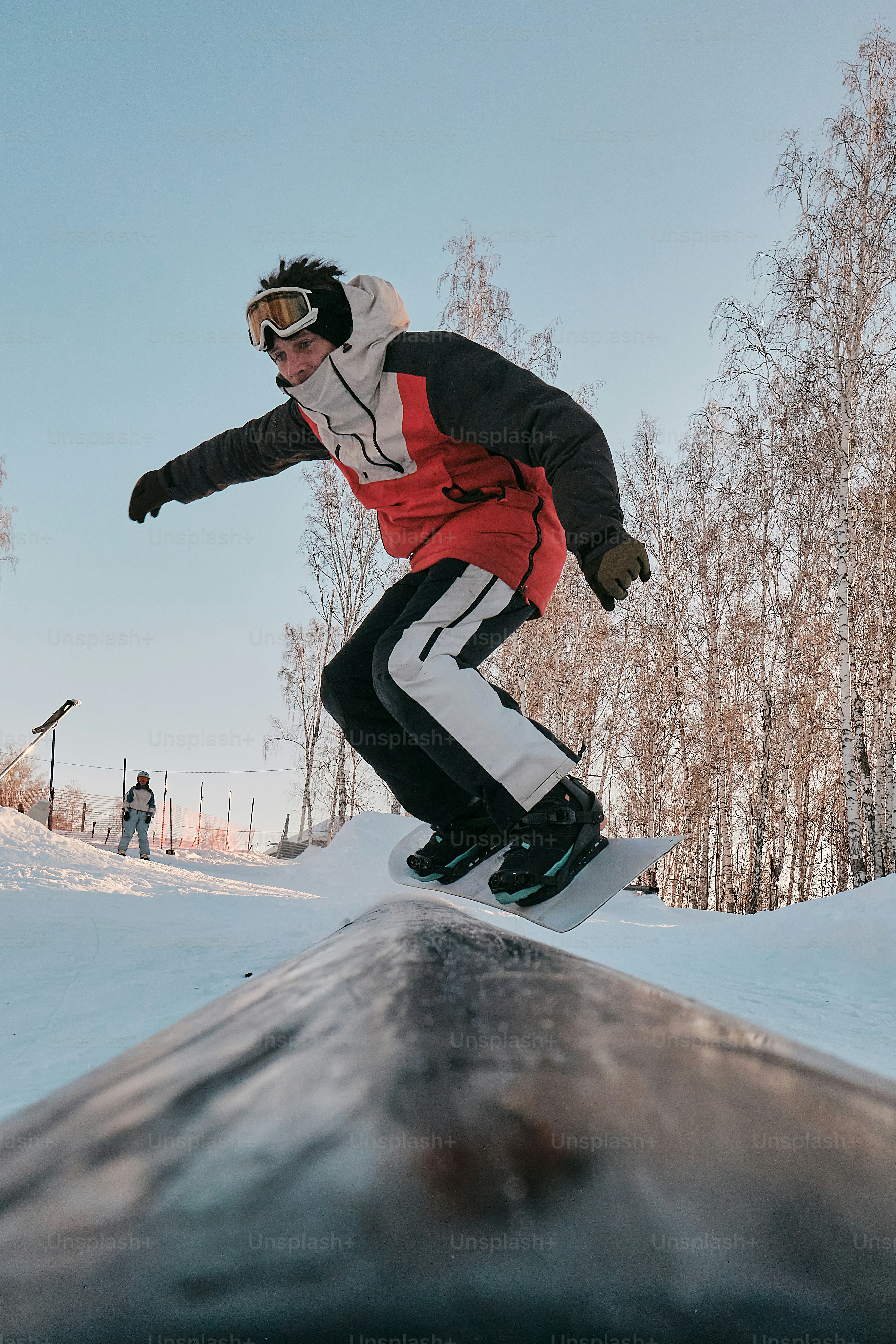 A man riding a snowboard down the side of a snow covered slope photo ...