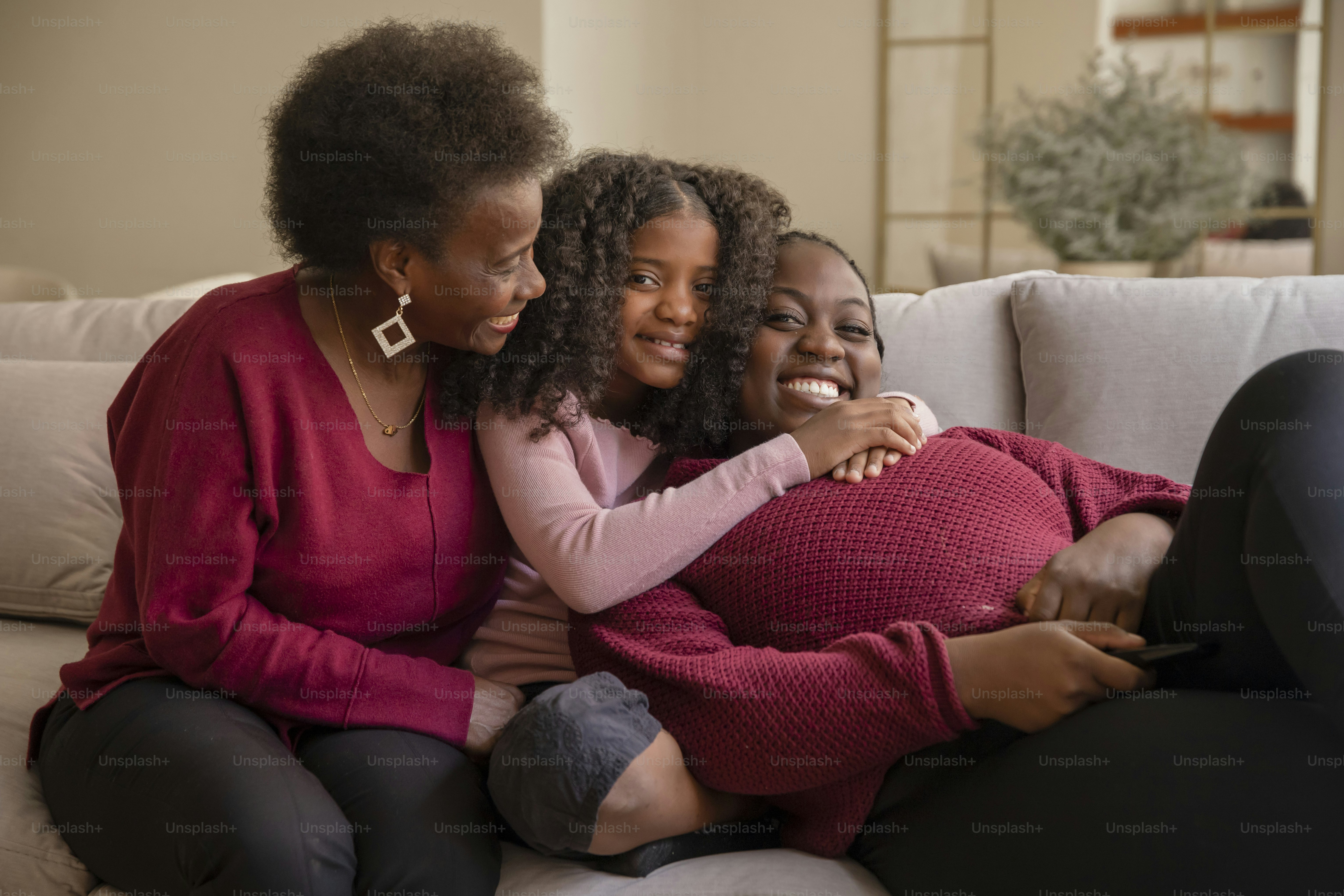 Three women sitting on a couch hugging each other photo ...