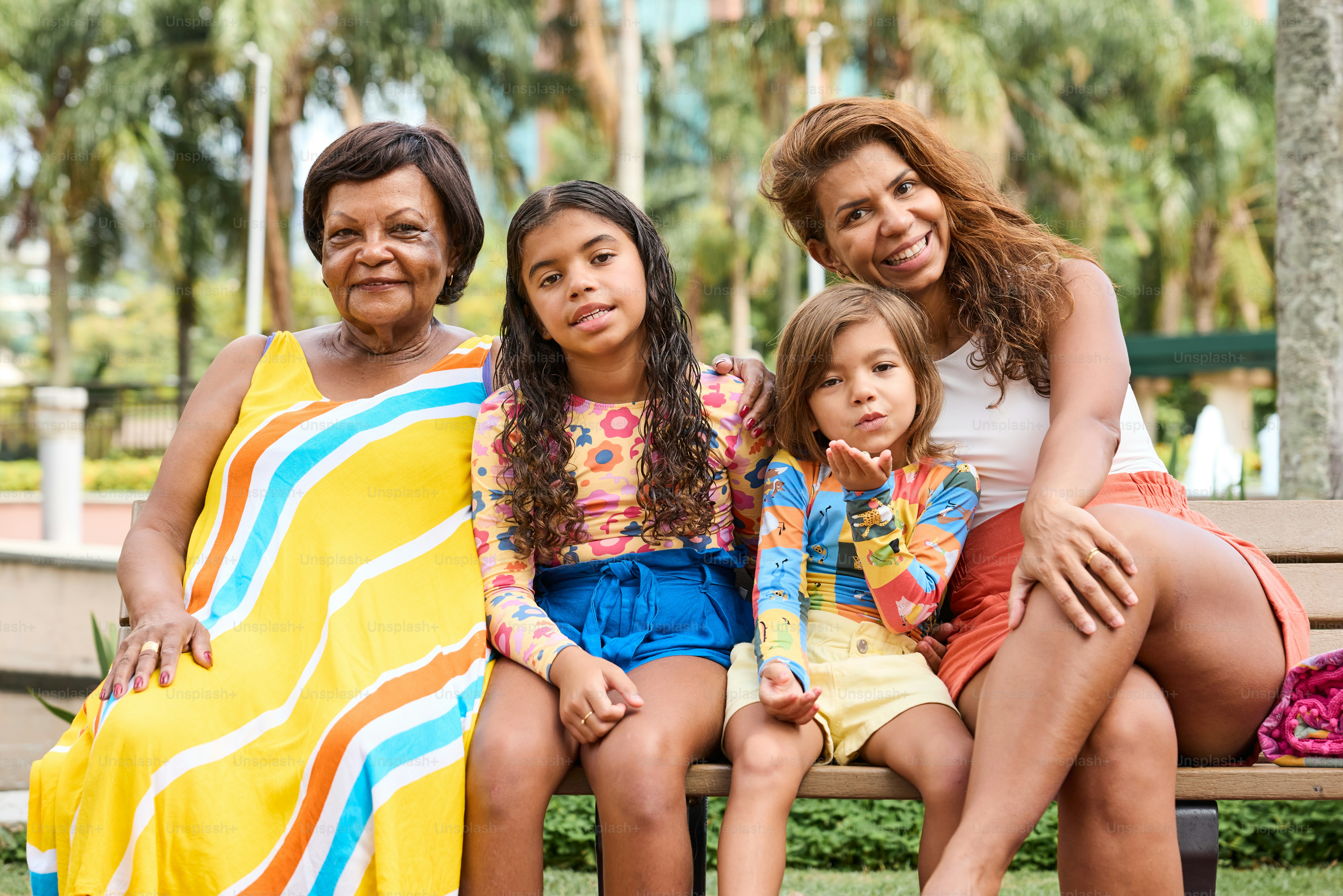 A group of women sitting on top of a wooden bench photo – Generations ...