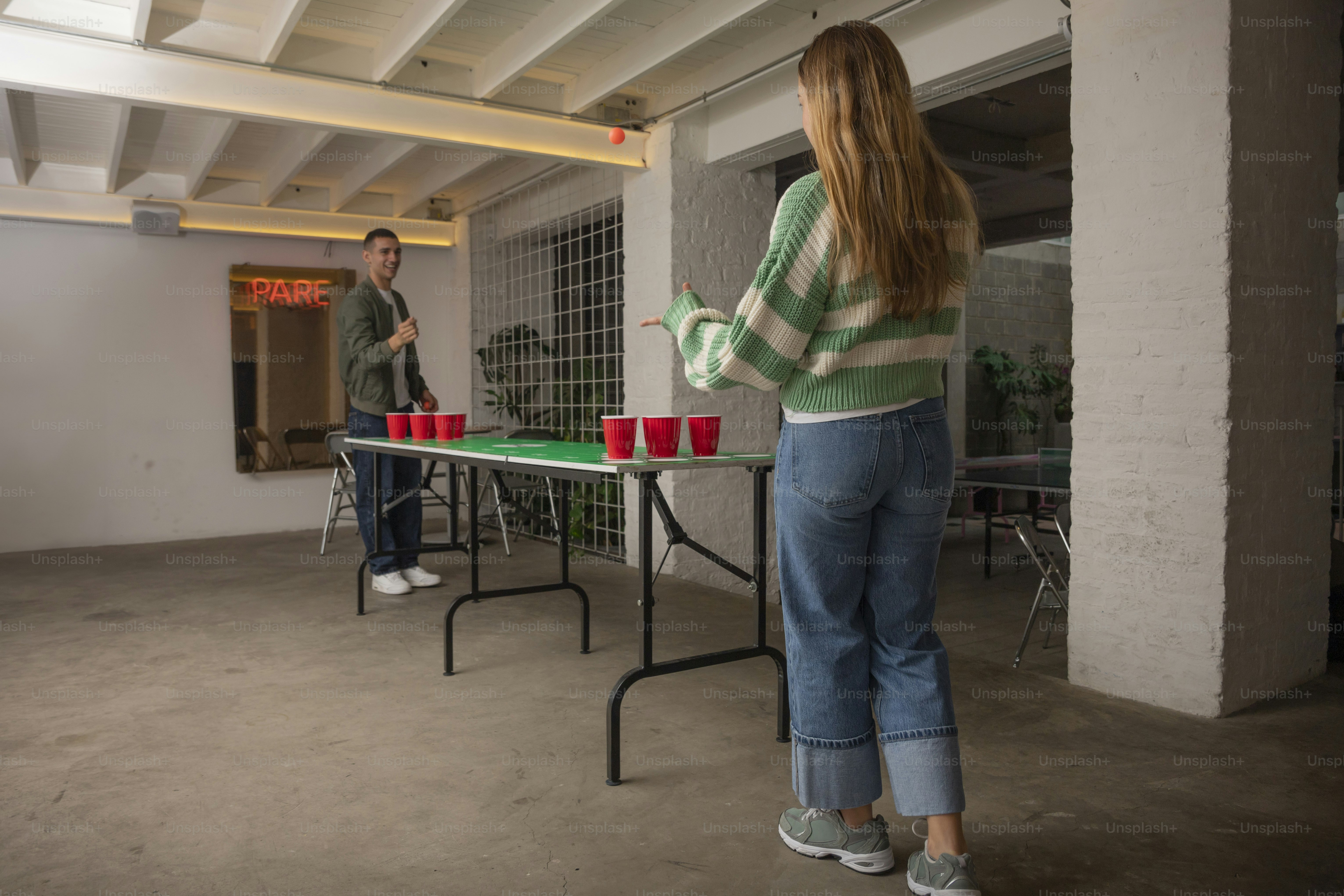 A man and a woman playing a game of frisbee photo – Beer pong Image on ...
