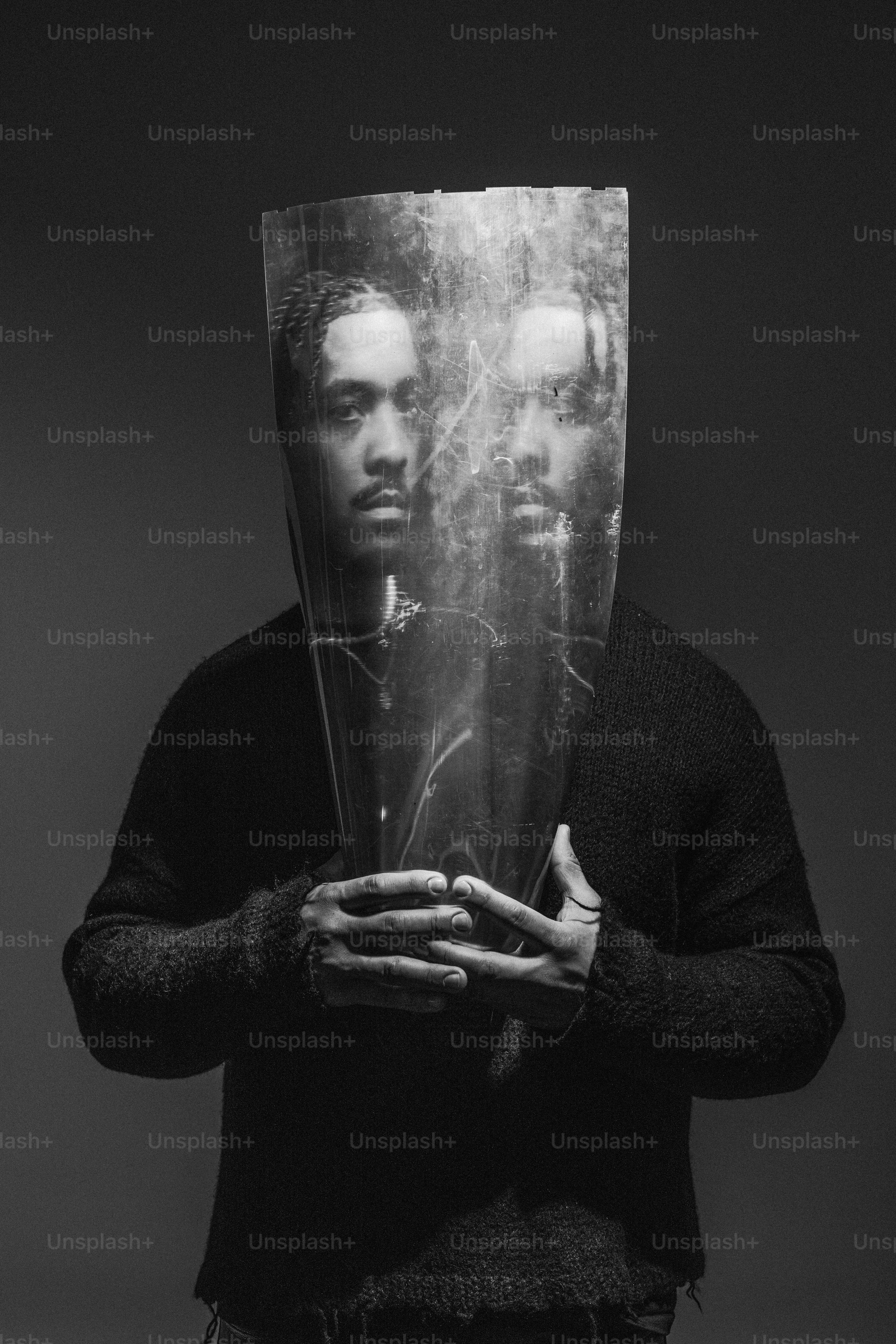 A man holding a mirror over his face photo – Self reflection Image on ...