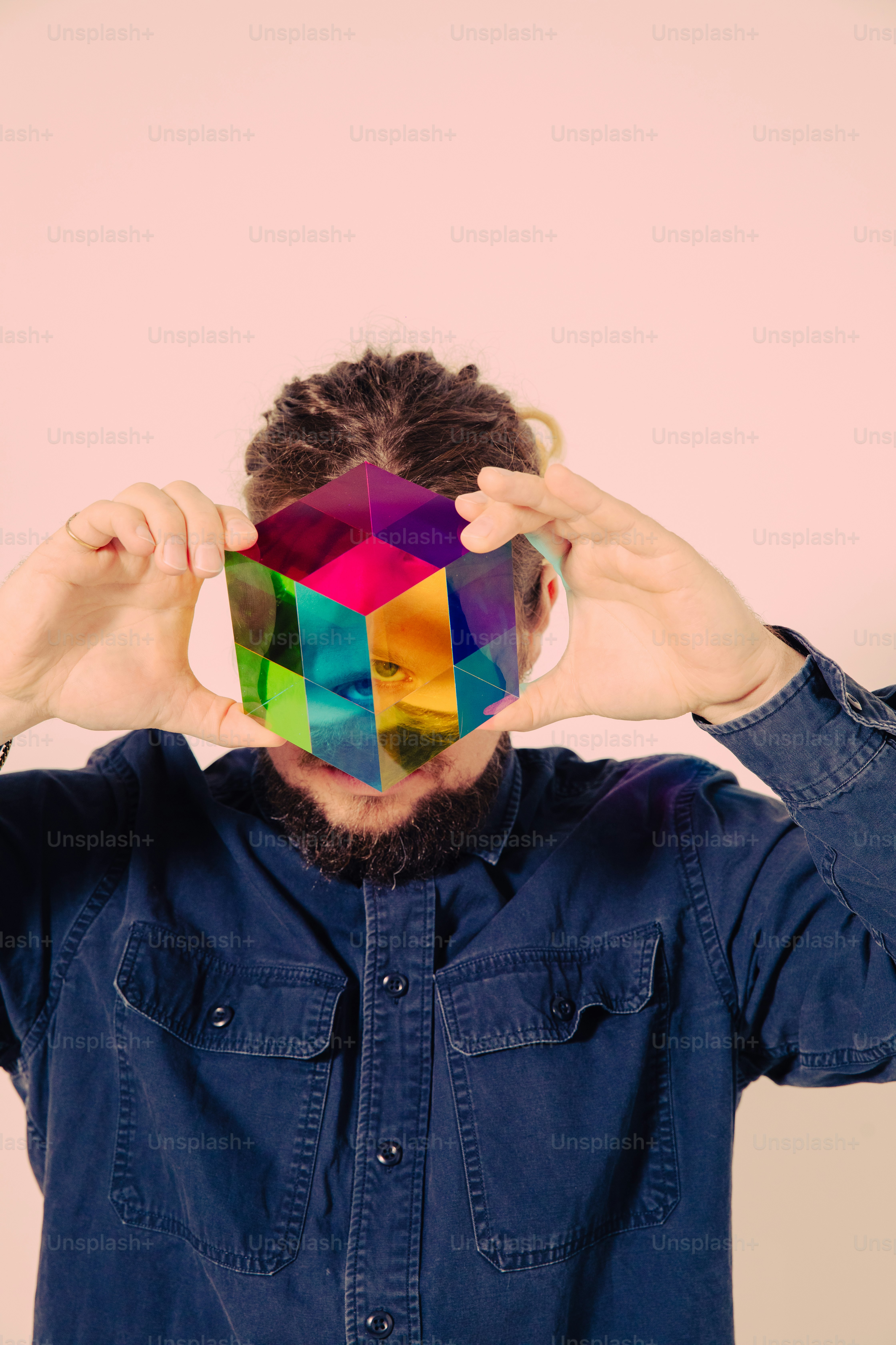 A woman holding a colorful cube in front of her face photo ...