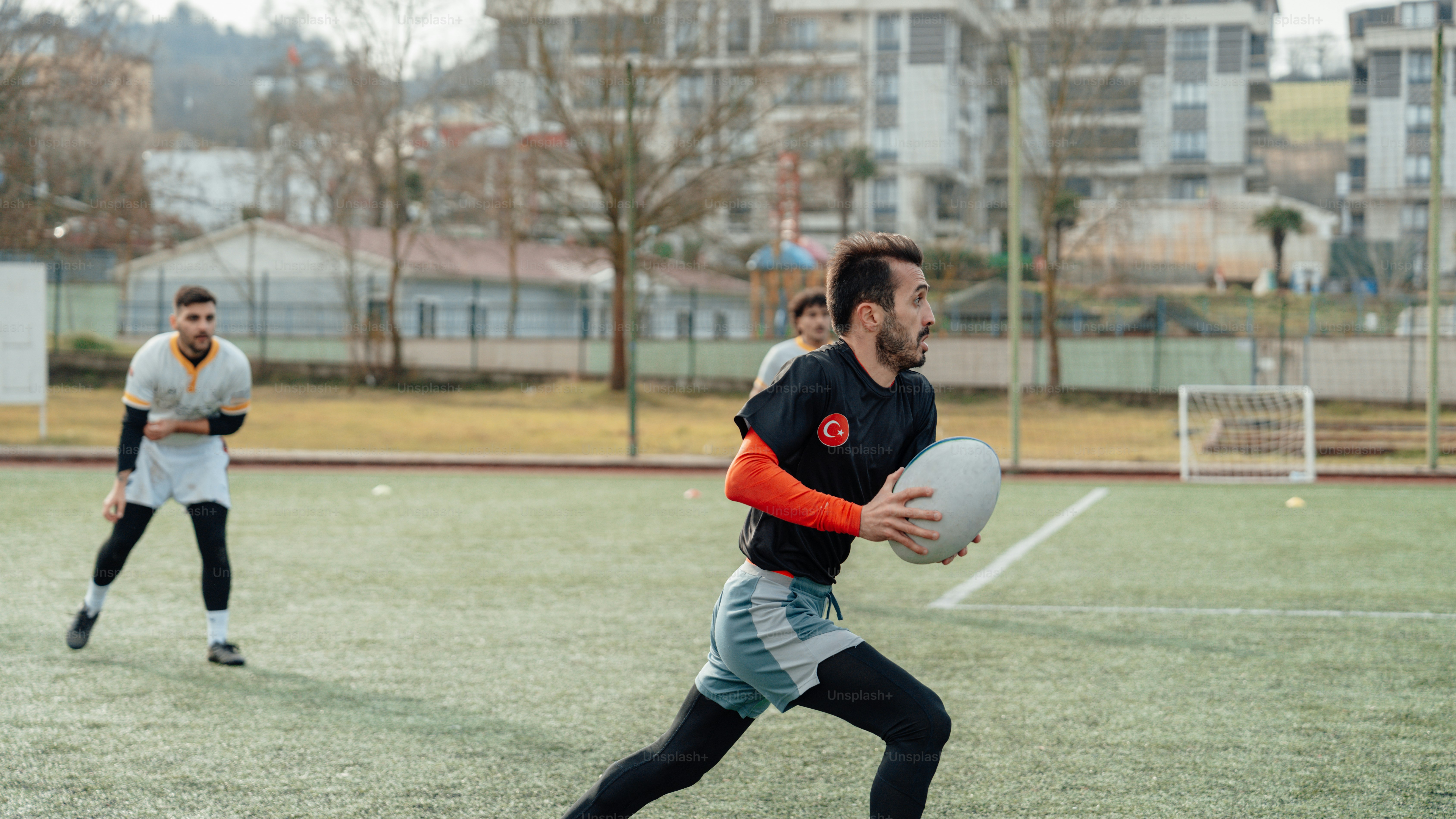 A man holding a white frisbee on top of a field photo – Sport Image on ...
