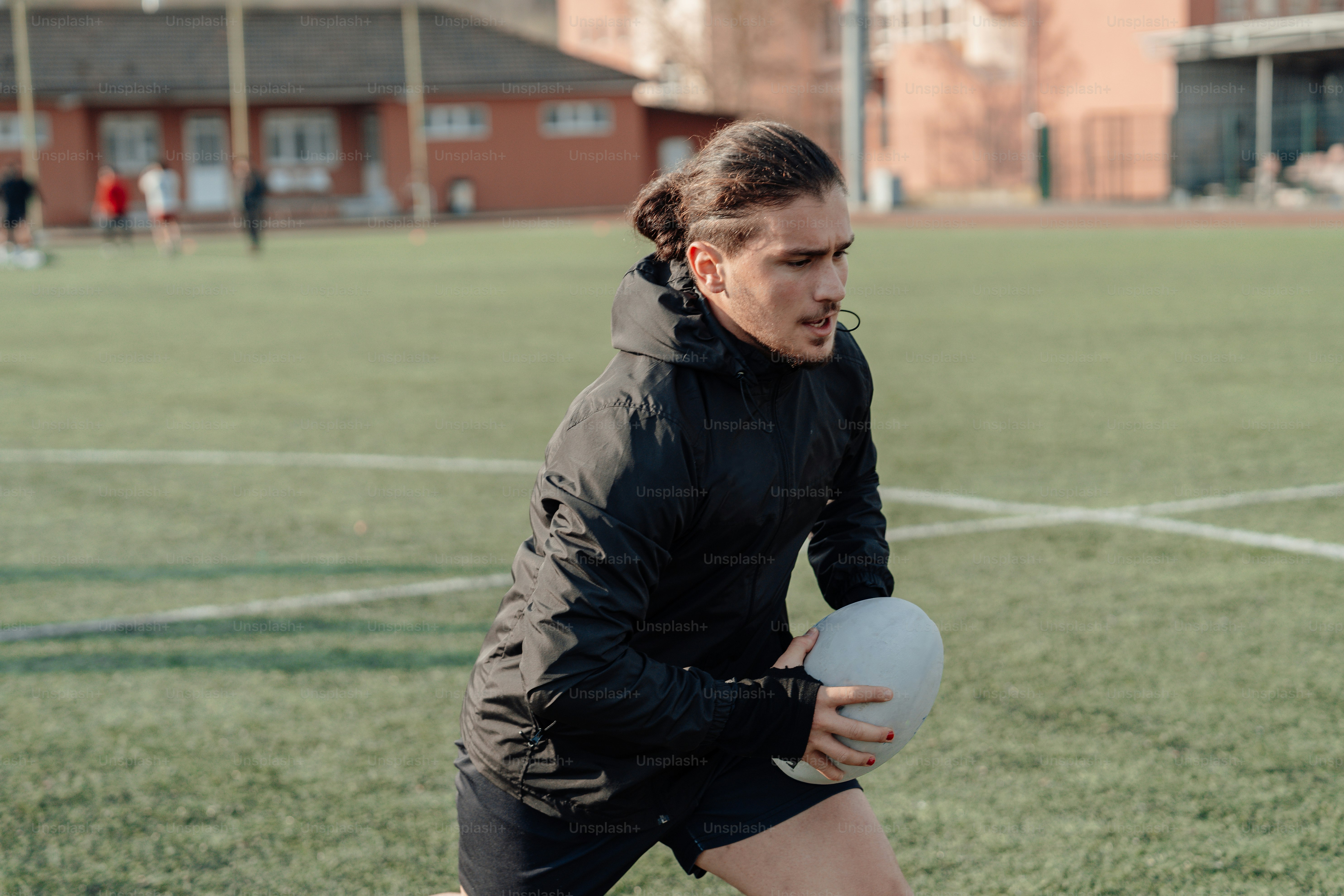 A man holding a white frisbee on top of a field photo – Sport Image on ...