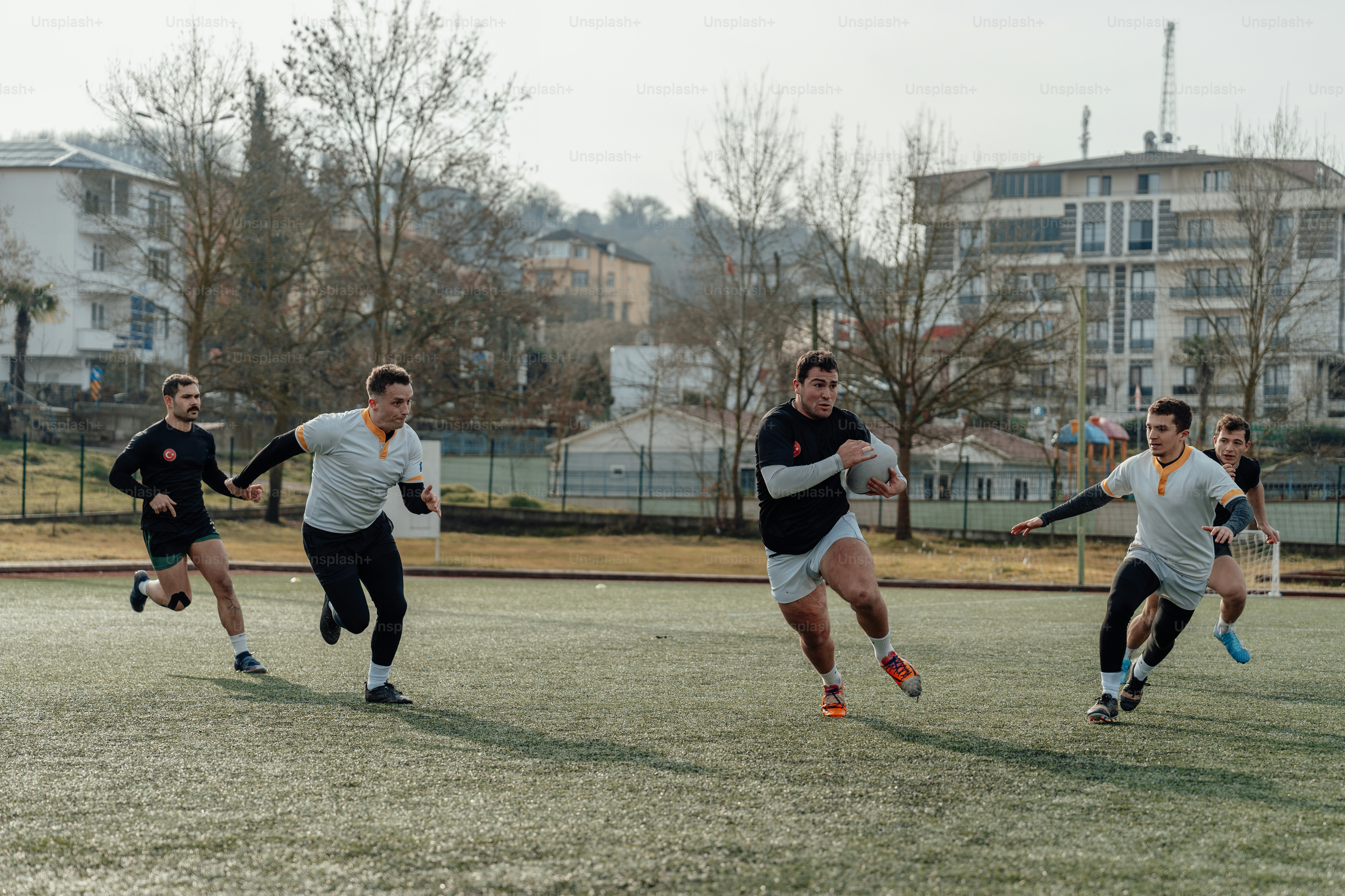 A group of young men playing a game of frisbee photo – Rugby ball Image ...