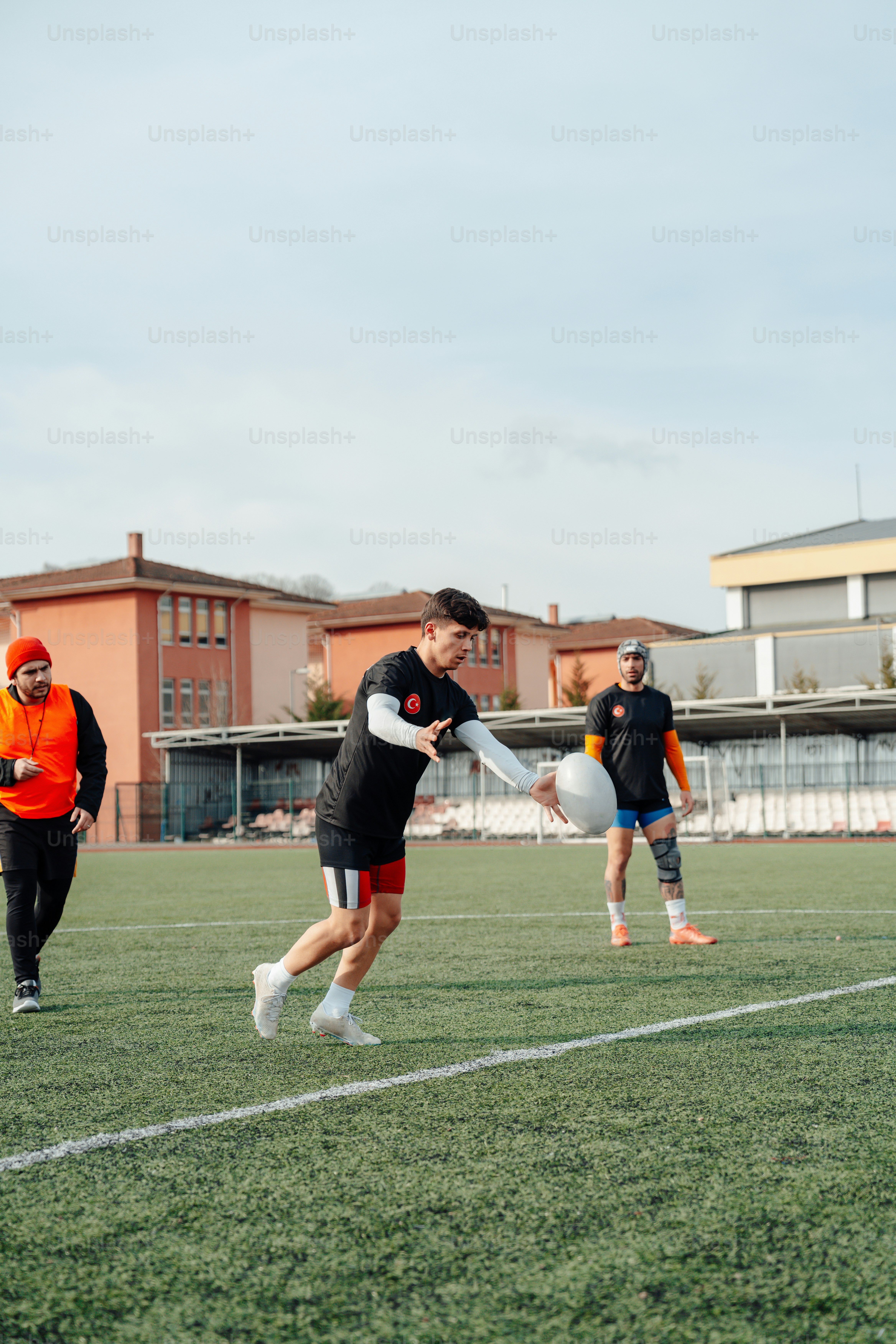 A group of young men playing a game of frisbee photo – Rugby ball Image ...