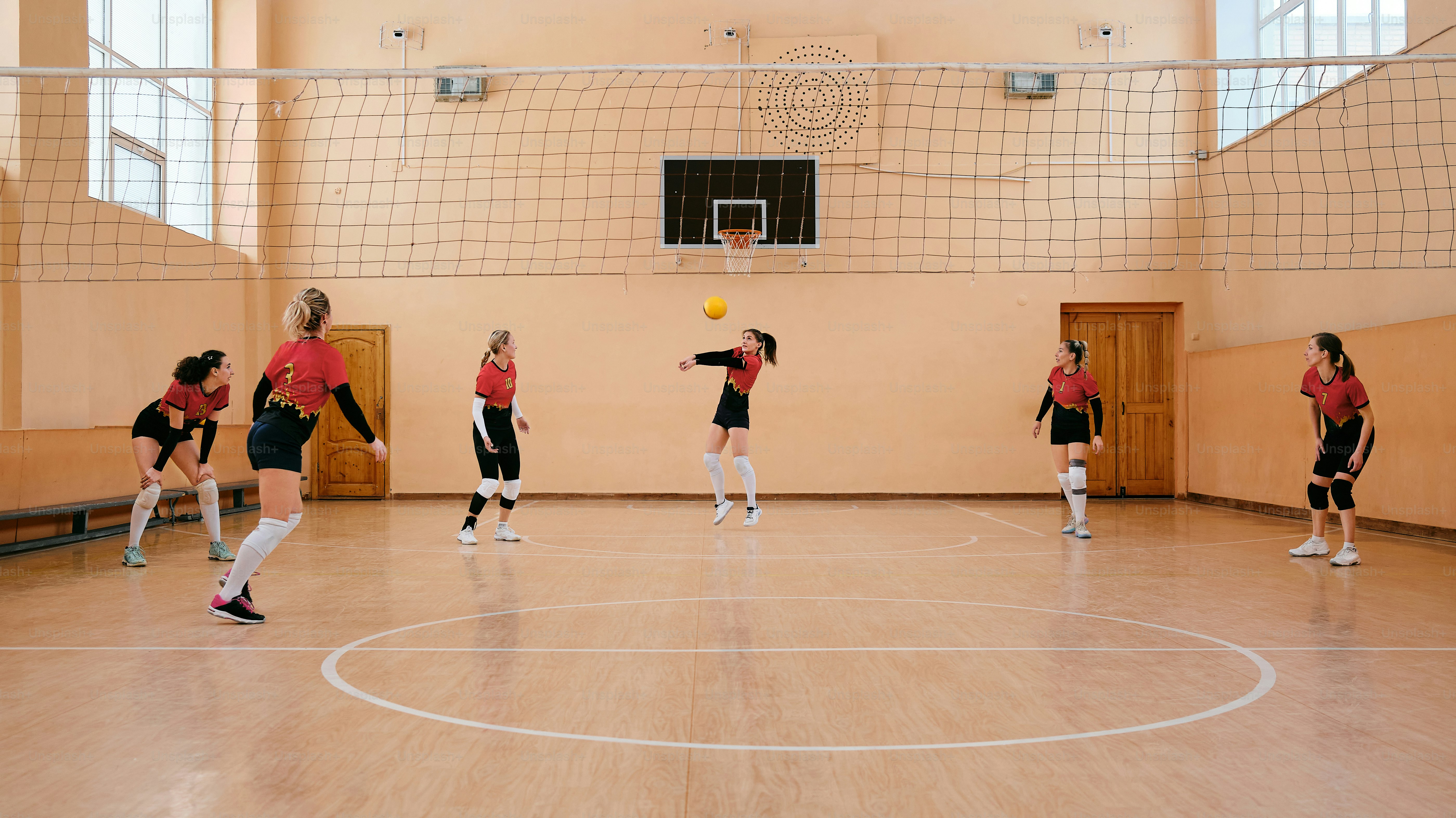 A group of women playing a game of volleyball photo – Team Image on ...