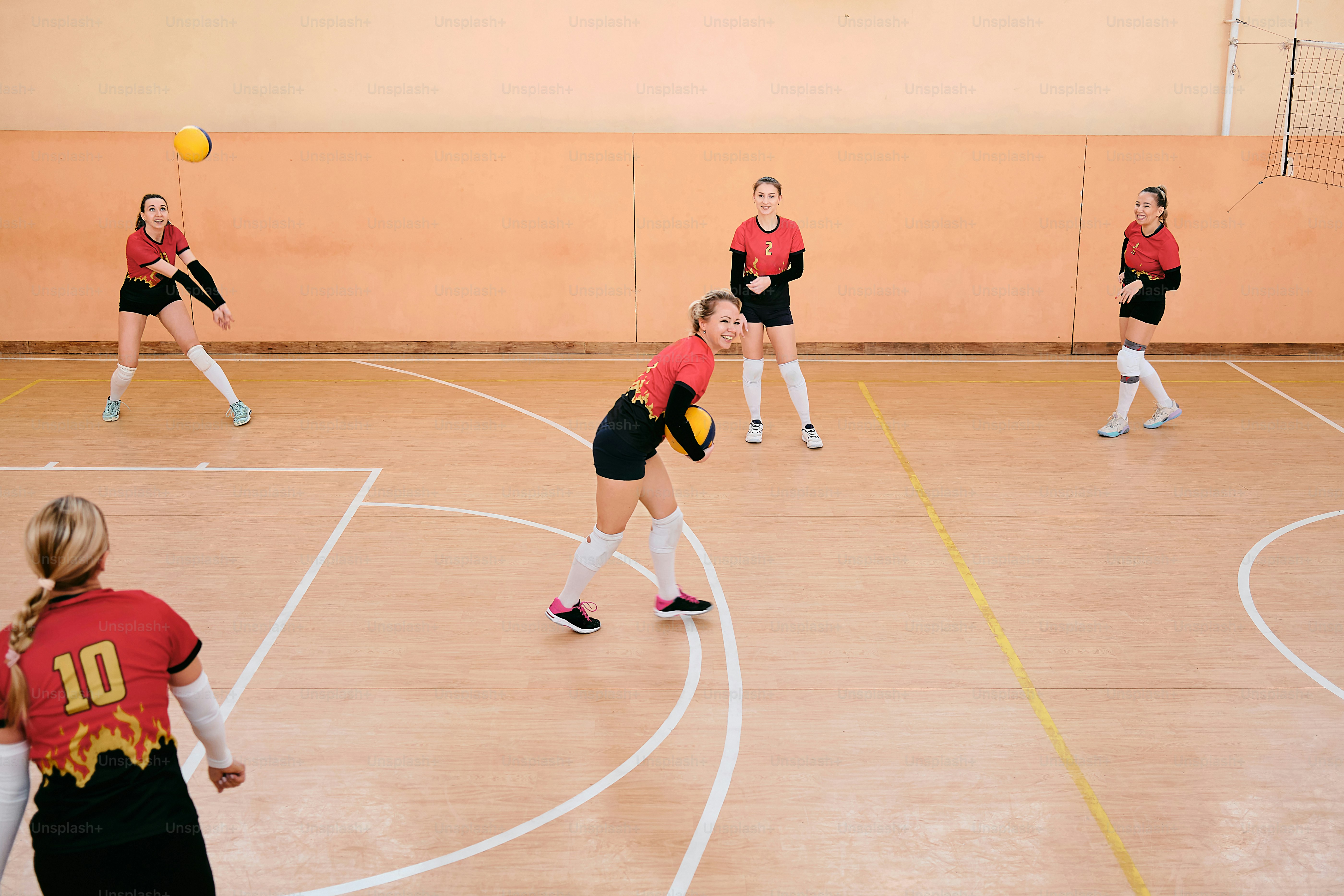 A group of women playing a game of volleyball photo – Team Image on ...