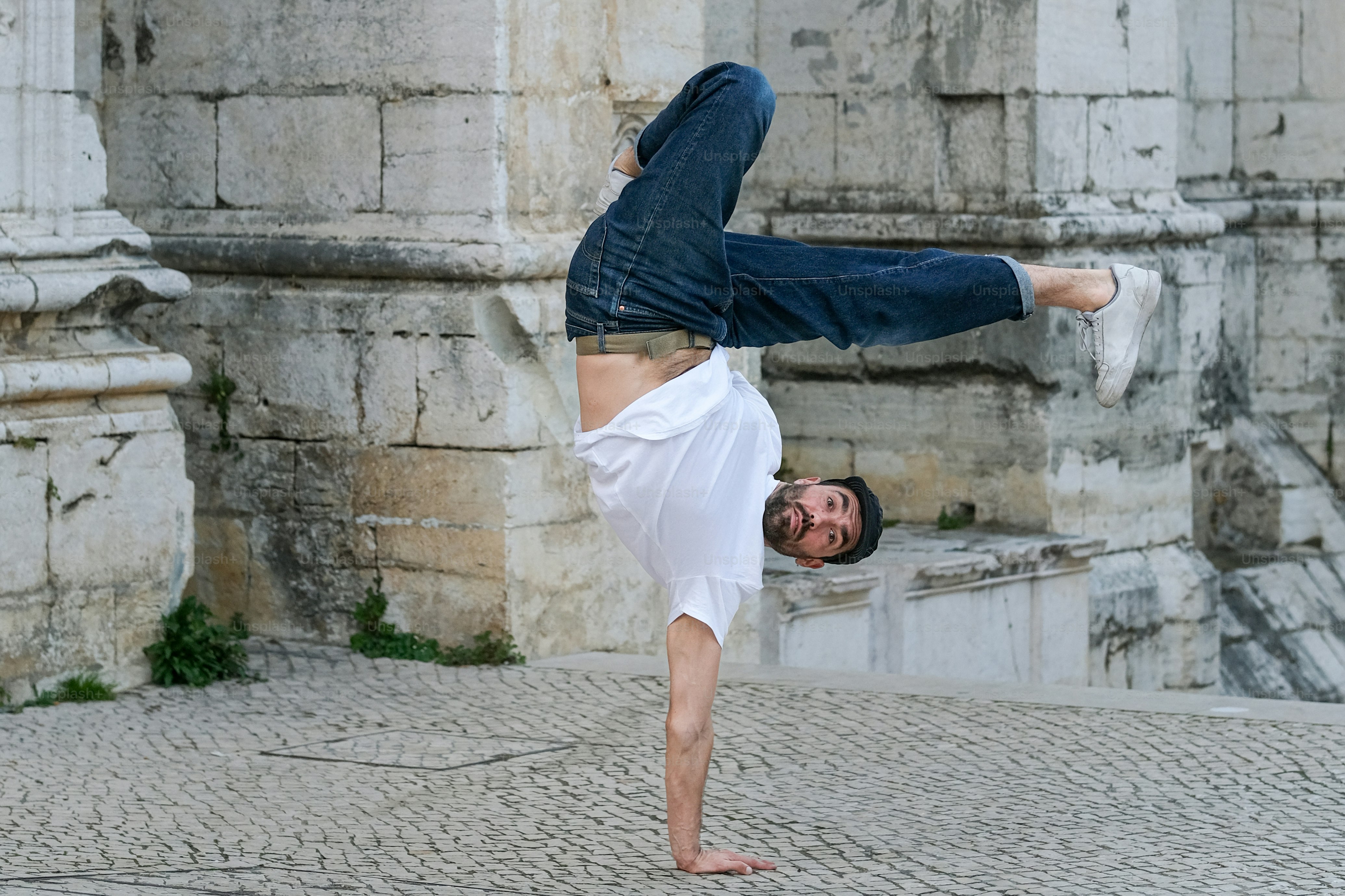 Un homme faisant le poirier devant un bâtiment photo – Urbain Photo sur ...
