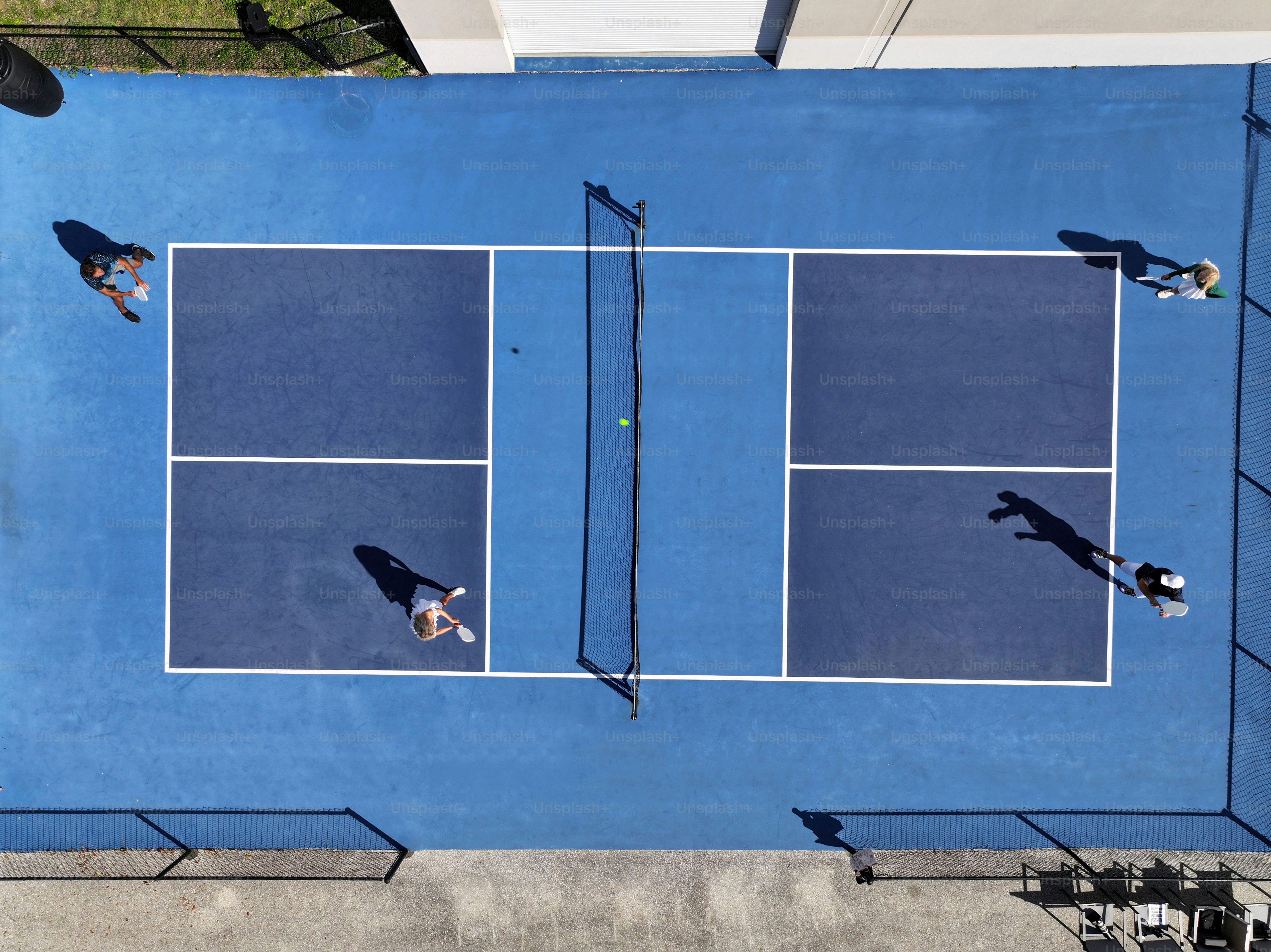 Foto Dos personas jugando al tenis en una cancha de tenis azul ...