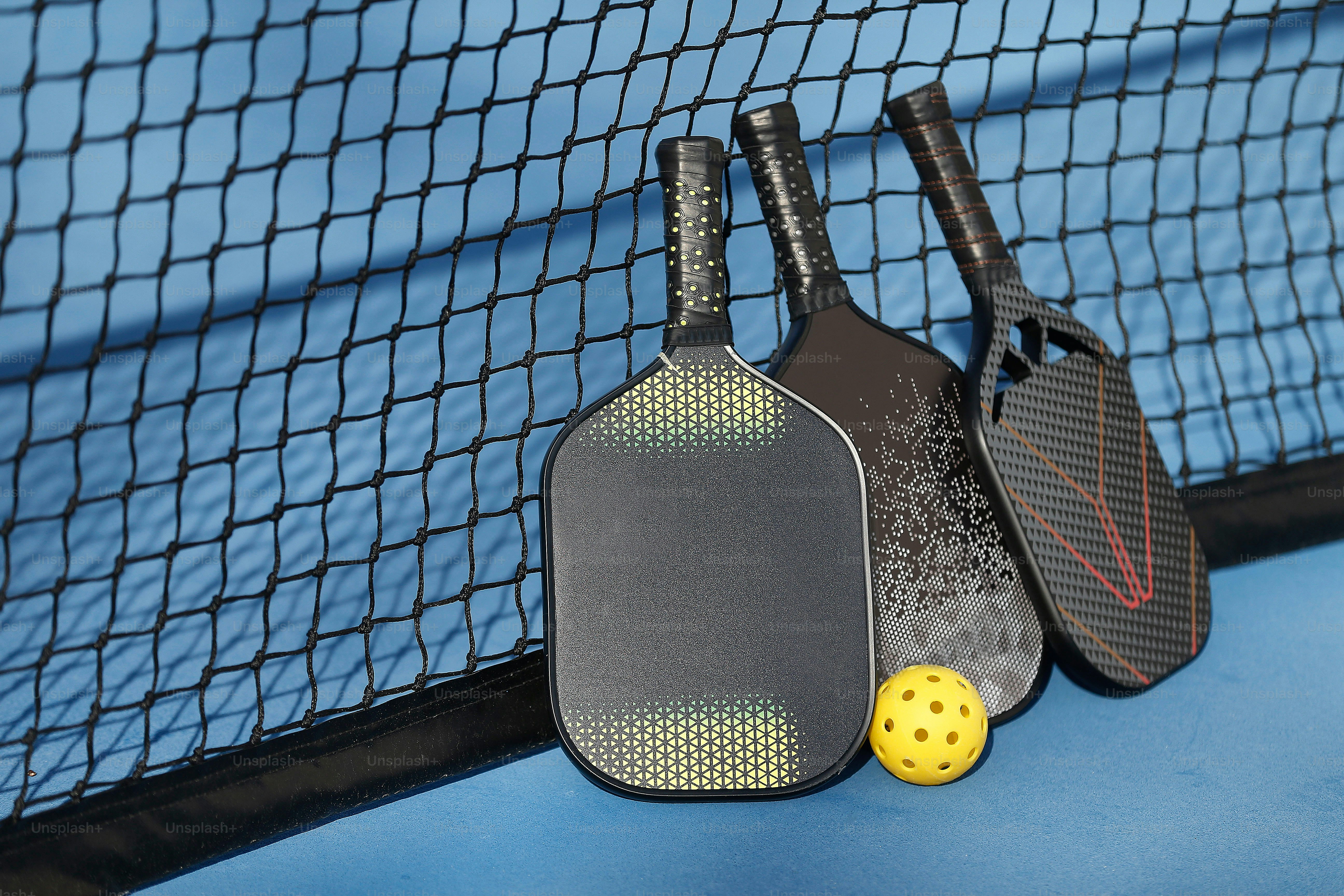 Two paddles and a paddle ball on a blue surface photo – Sports Image on ...