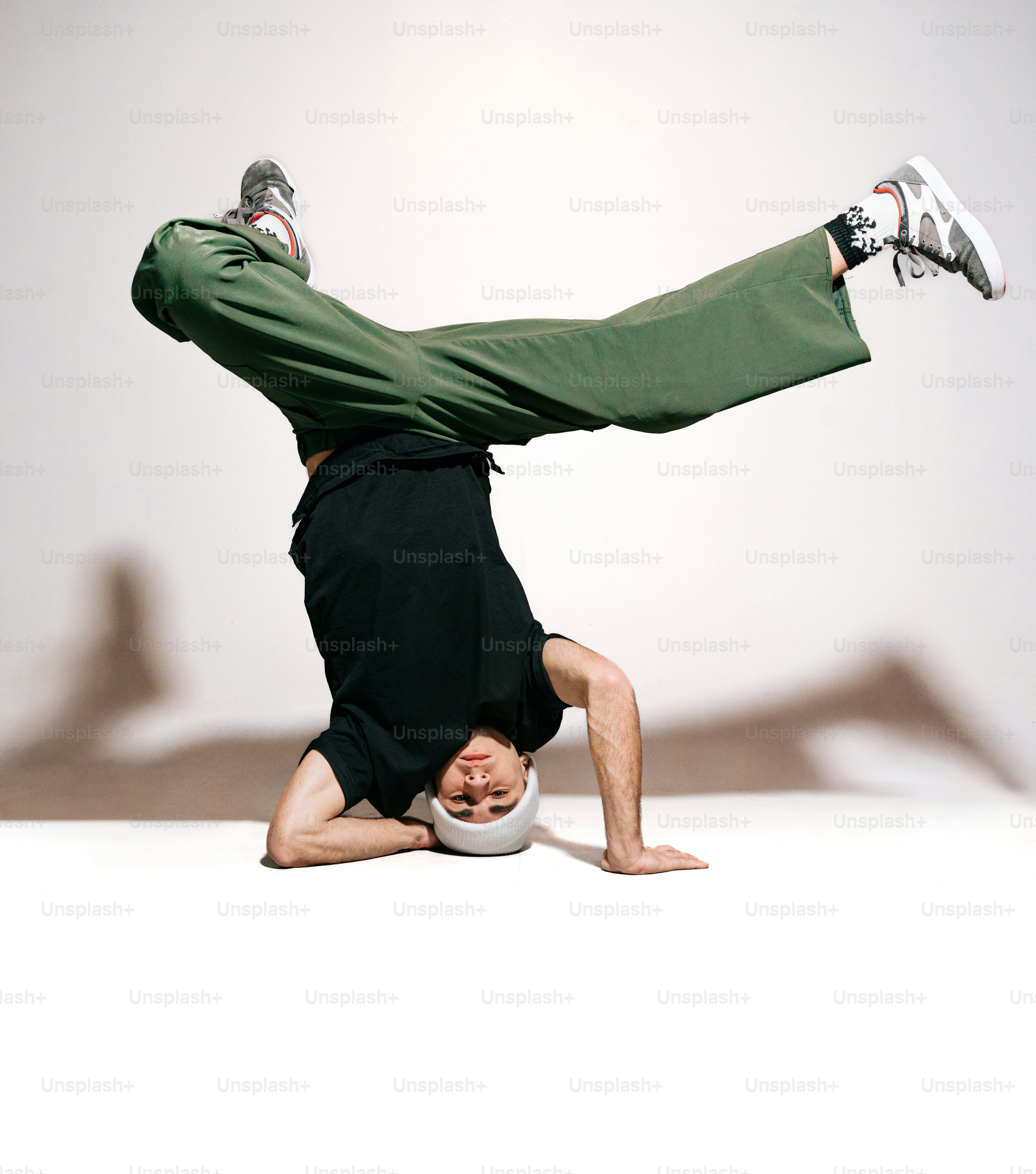A man doing a handstand on a white surface photo – Breakdance Image on ...
