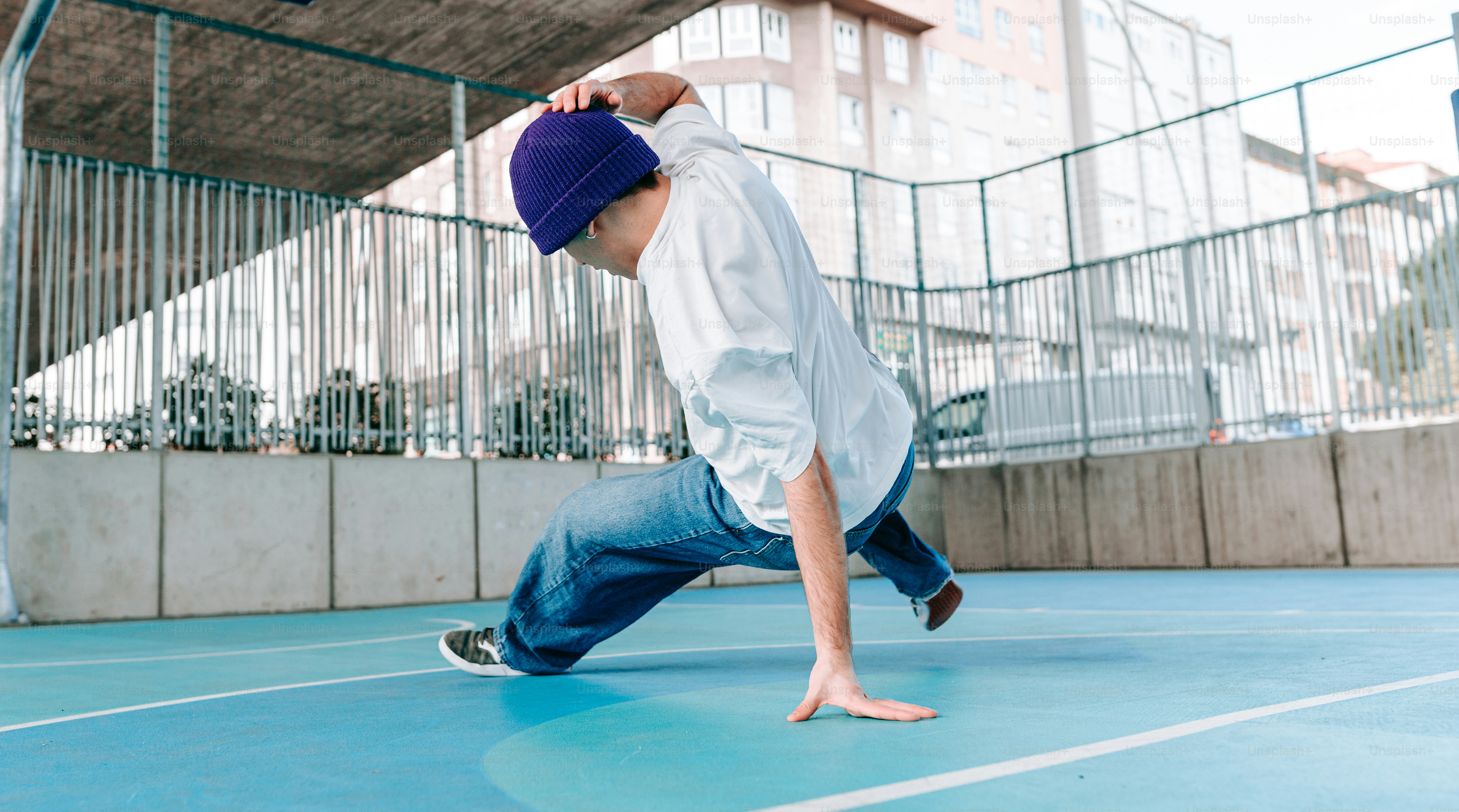 A man is doing a handstand on a tennis court photo – Street Image on ...