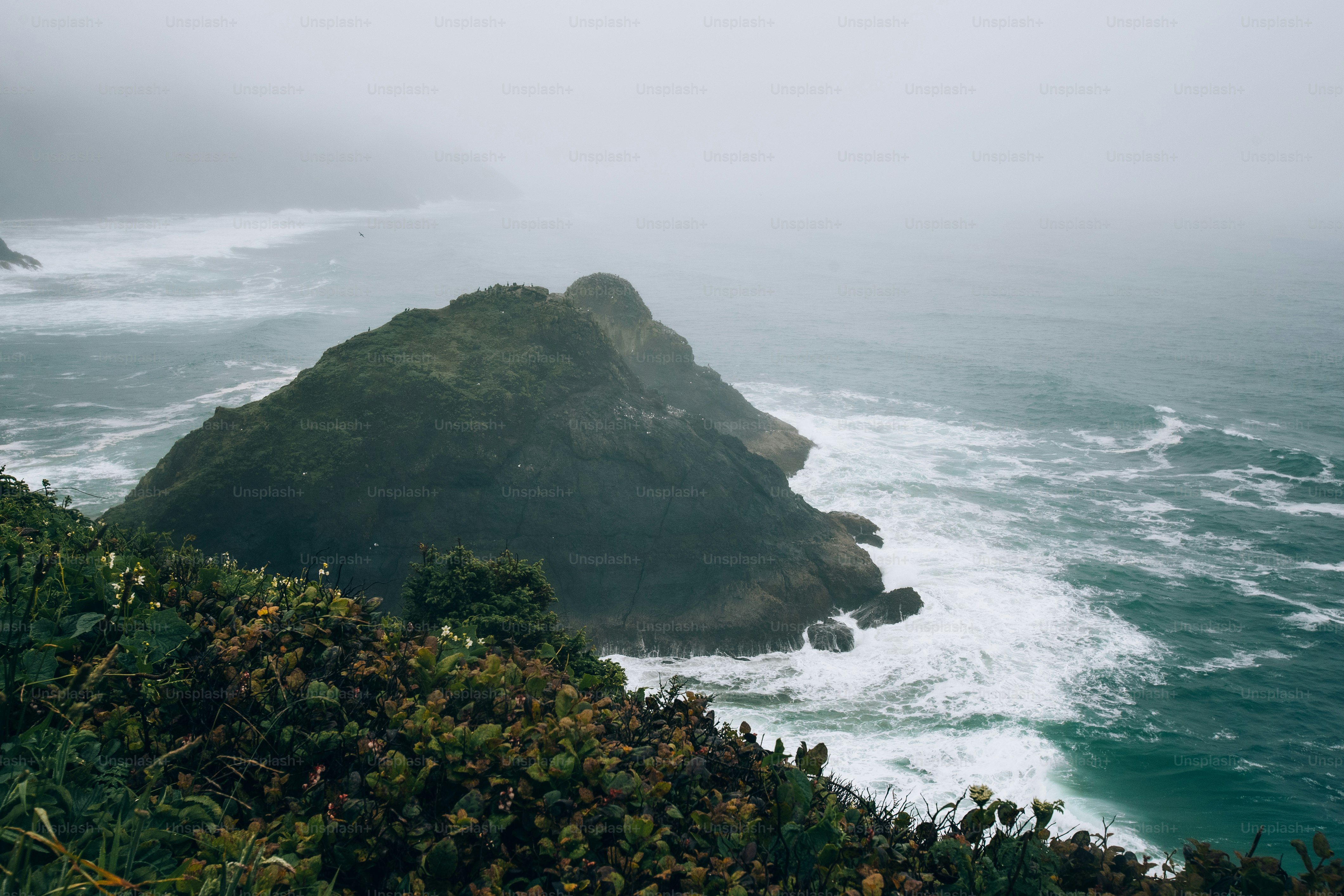 A large rock sitting on top of a lush green hillside photo – Promontory ...