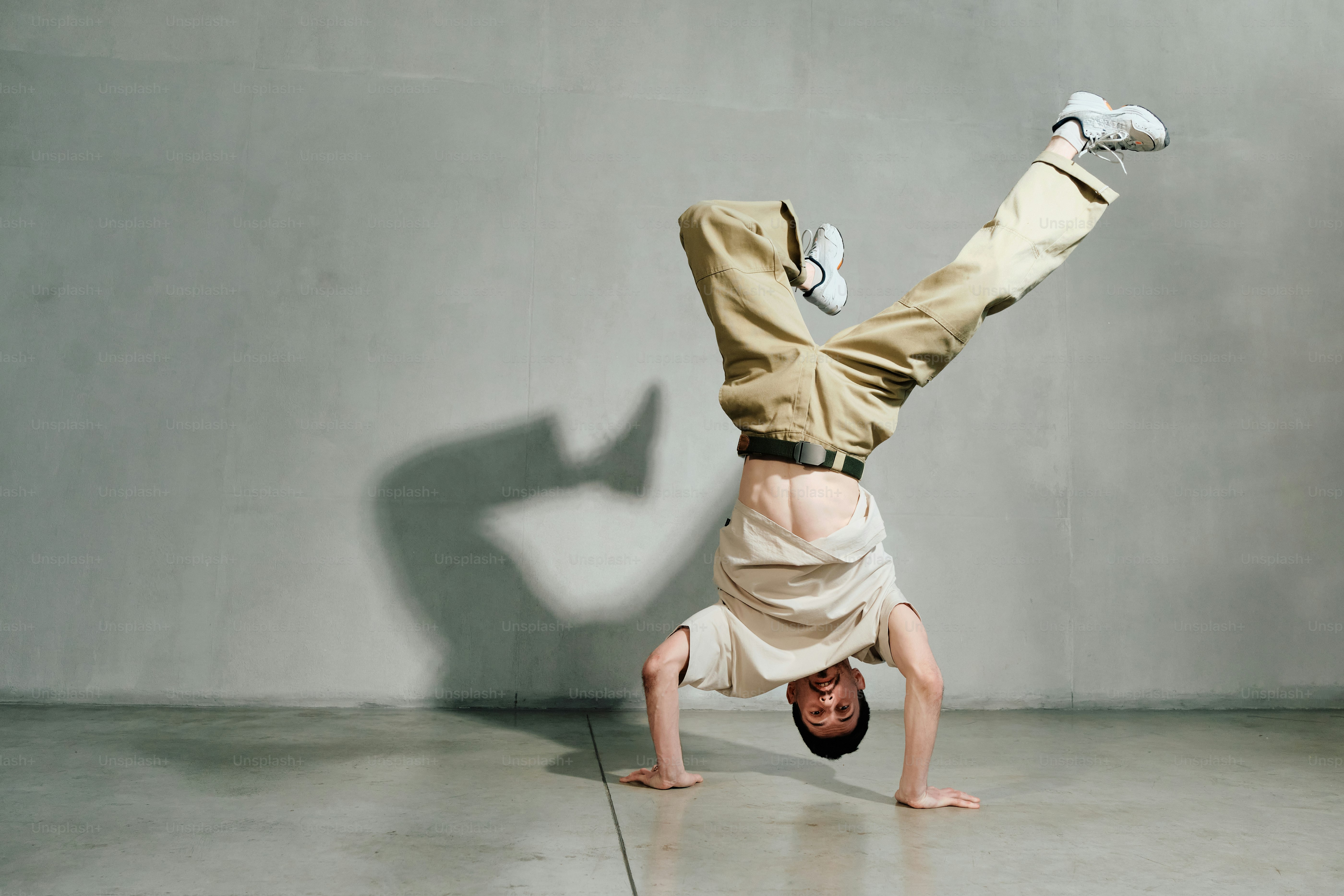 Un homme faisant le poirier dans une pièce photo – Image de Danseur sur ...