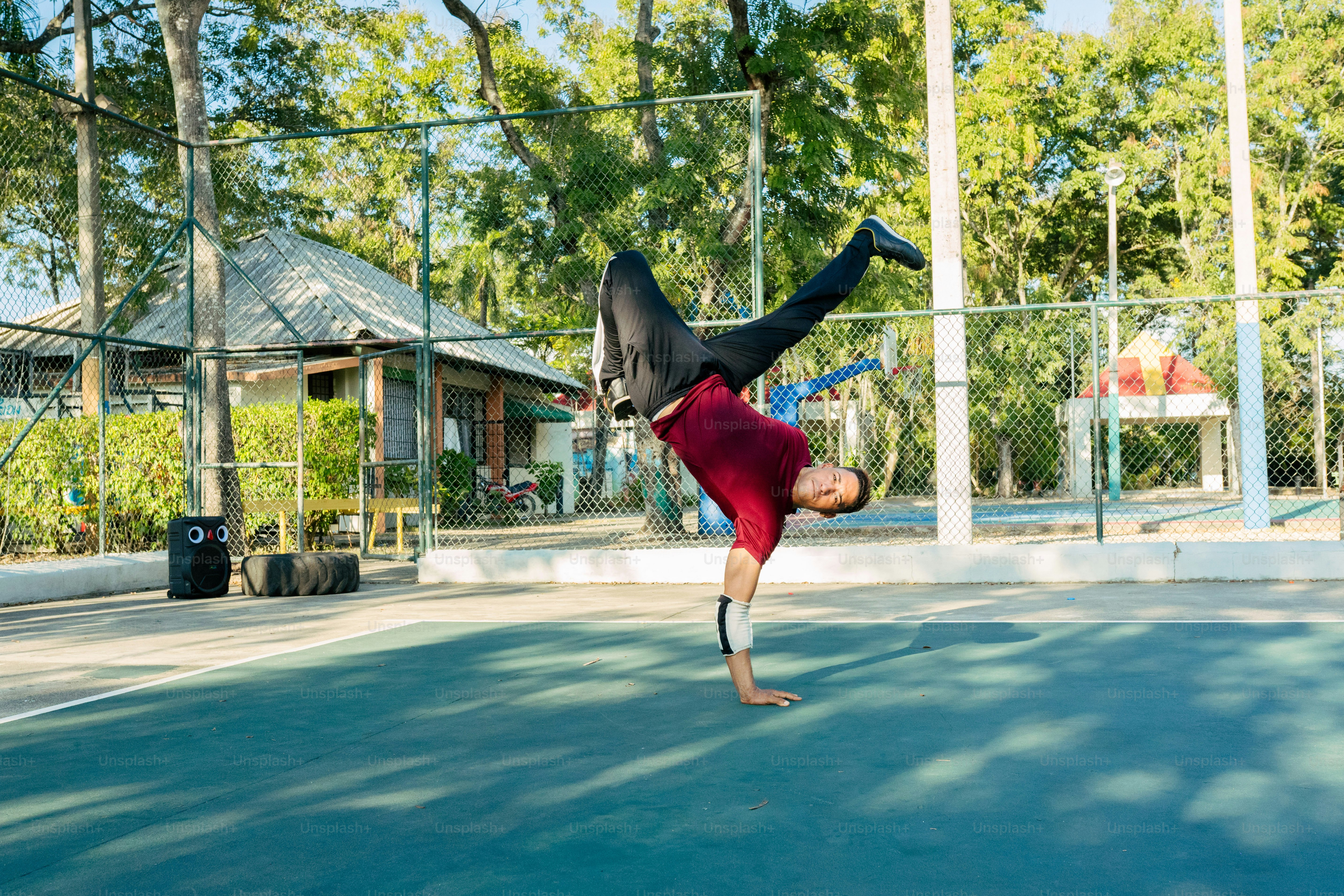 A man doing a handstand on a tennis court photo – Break dance Image on ...