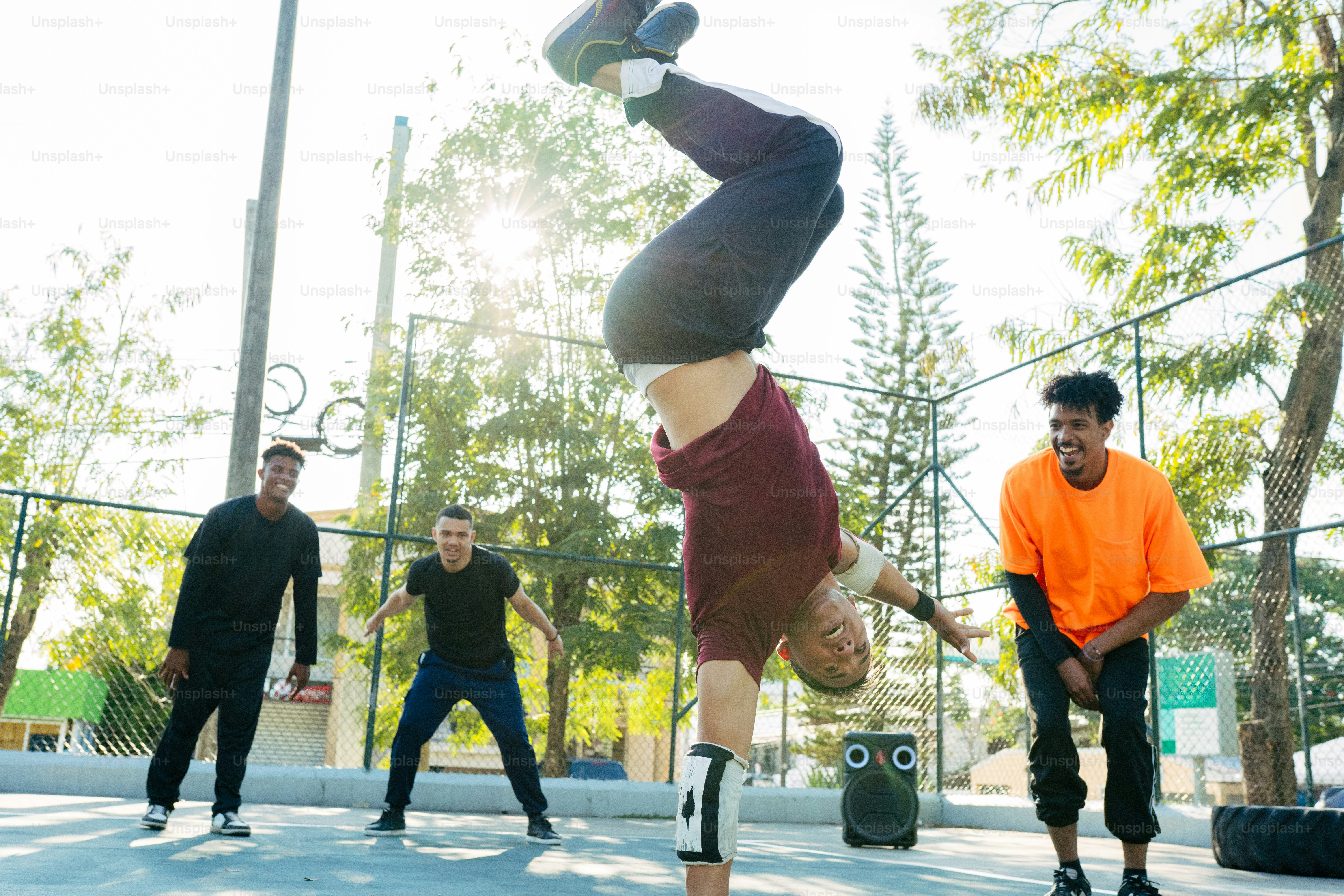 A group of people doing a handstand on a tennis court photo – Break ...