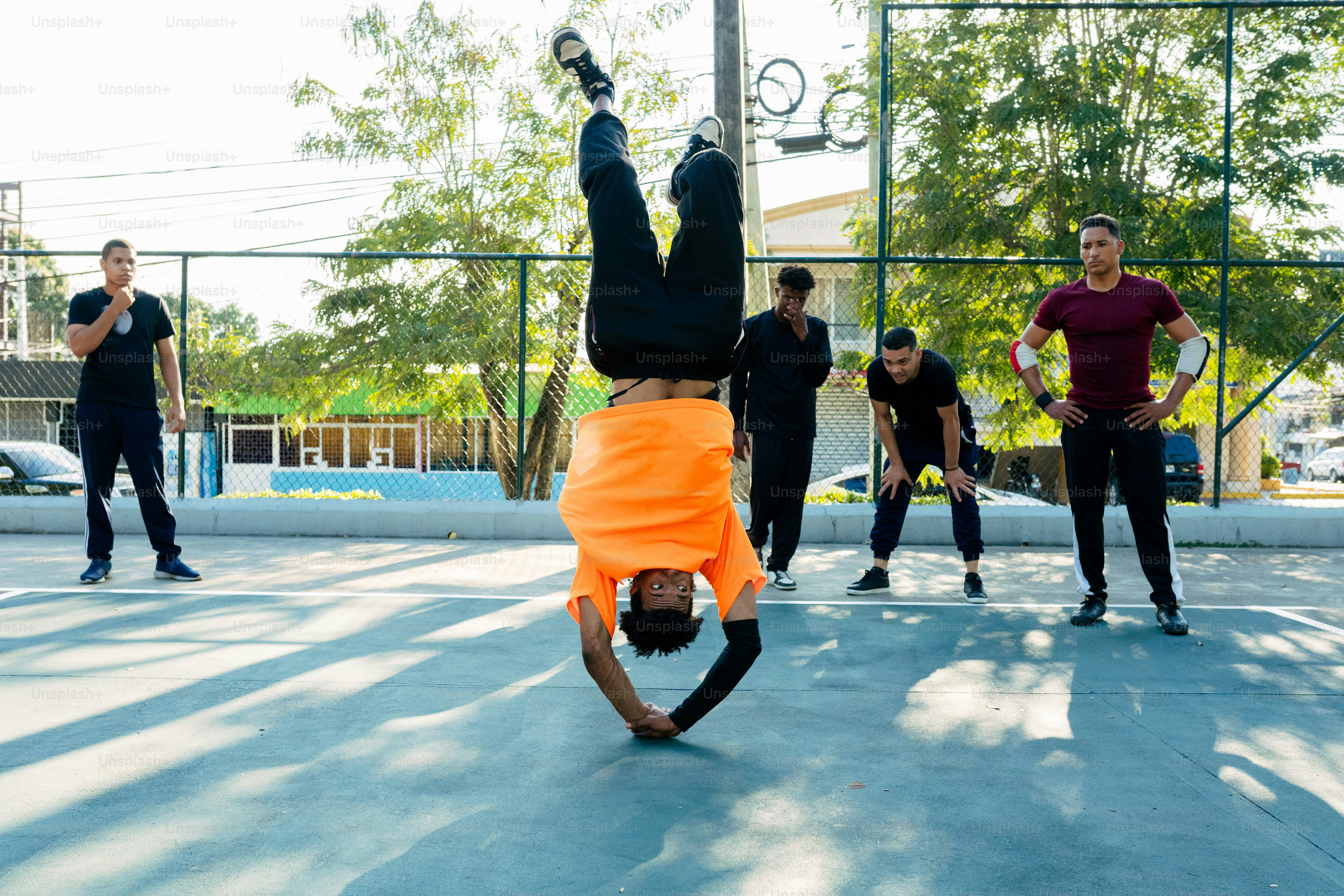 A man doing a handstand on a basketball court photo – Break dance Image ...