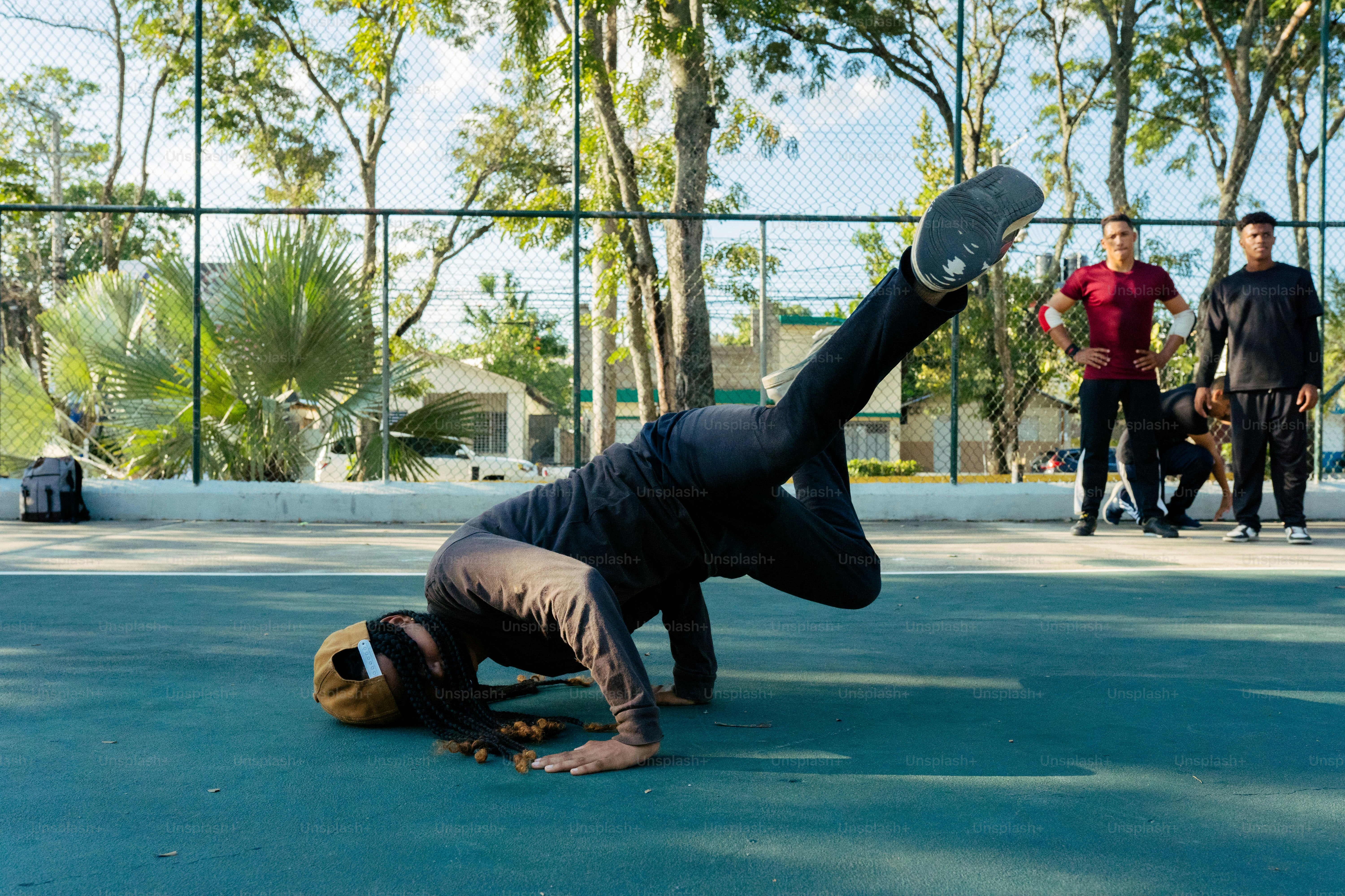 A man doing a handstand on a tennis court photo – Break dance Image on ...