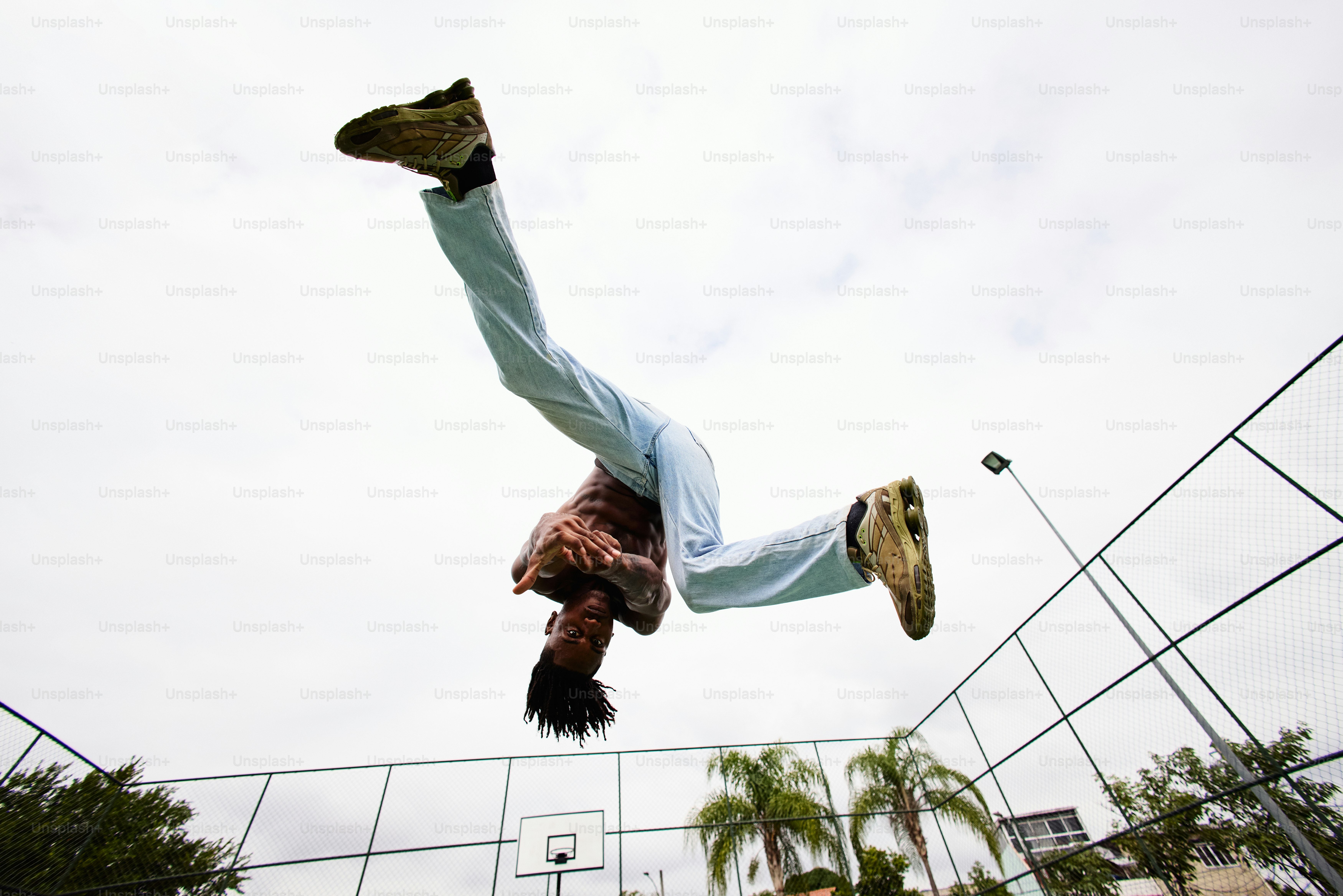 A person doing a handstand on a tennis court photo – Man Image on Unsplash