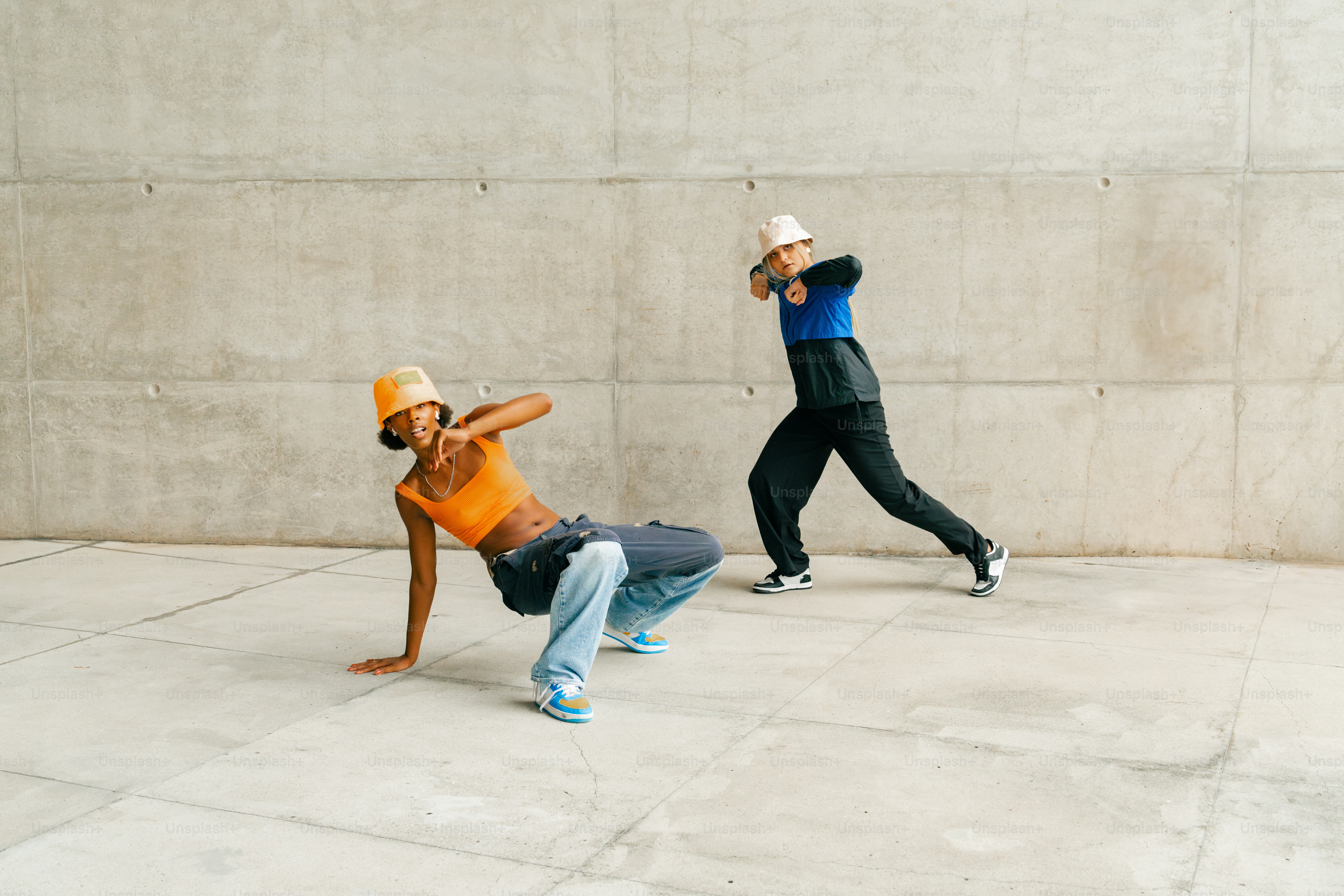 A woman in an orange shirt is doing a trick on a skateboard photo ...