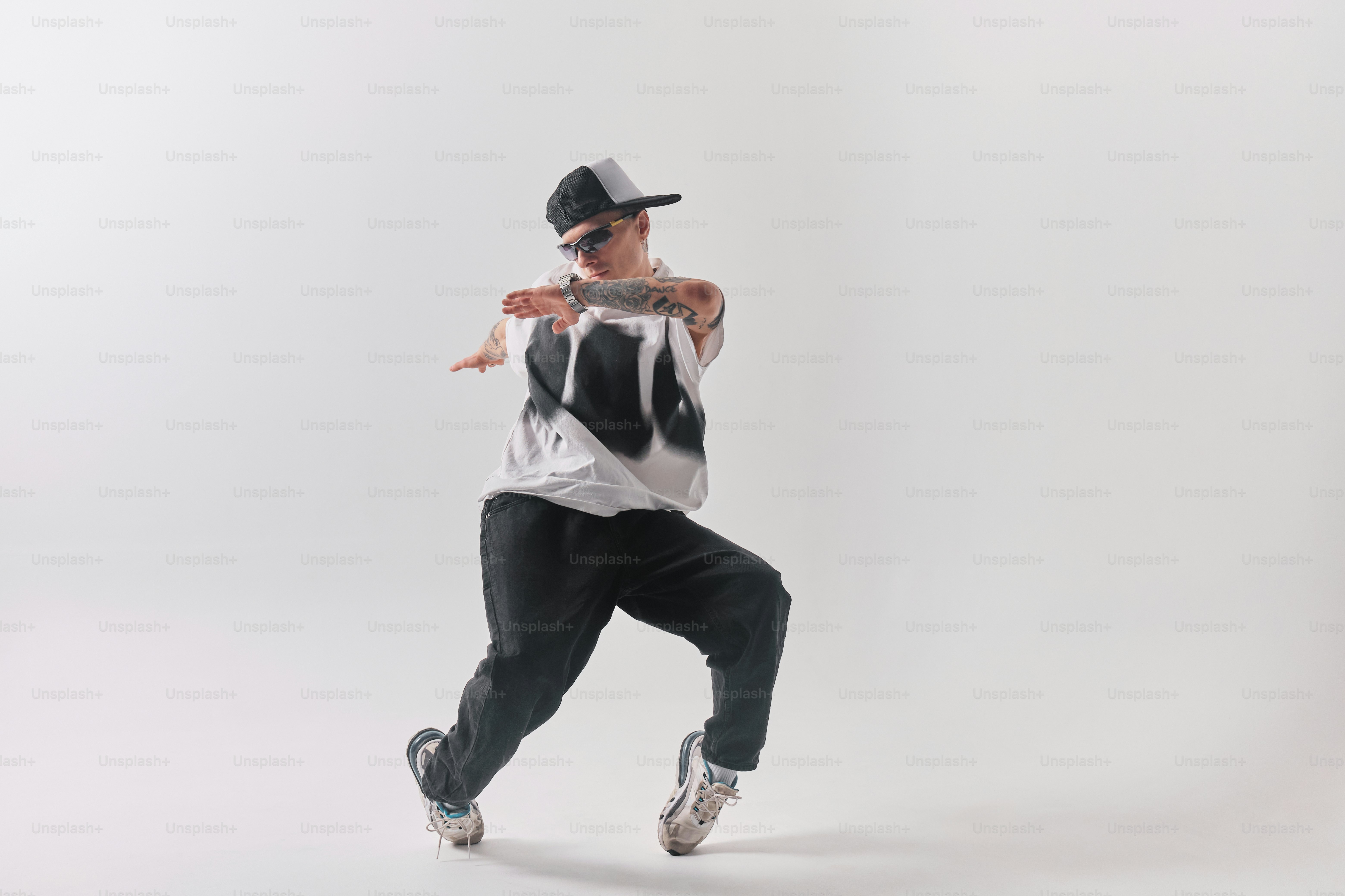 A man in a hat and sunglasses is dancing photo – Break dance Image on ...